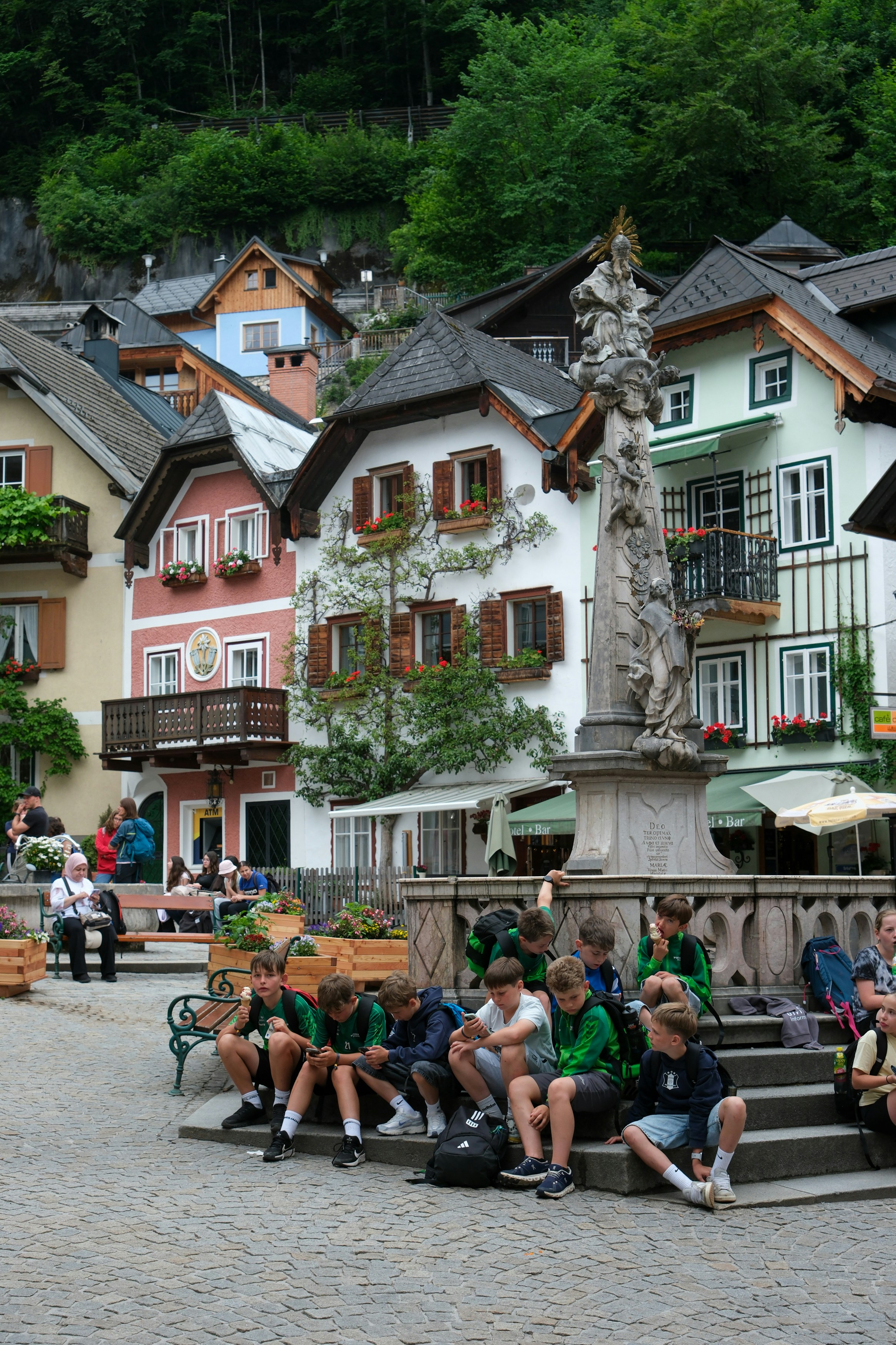 Colorful Alpine Village Square with a Monument and Curious Courtyard Groups