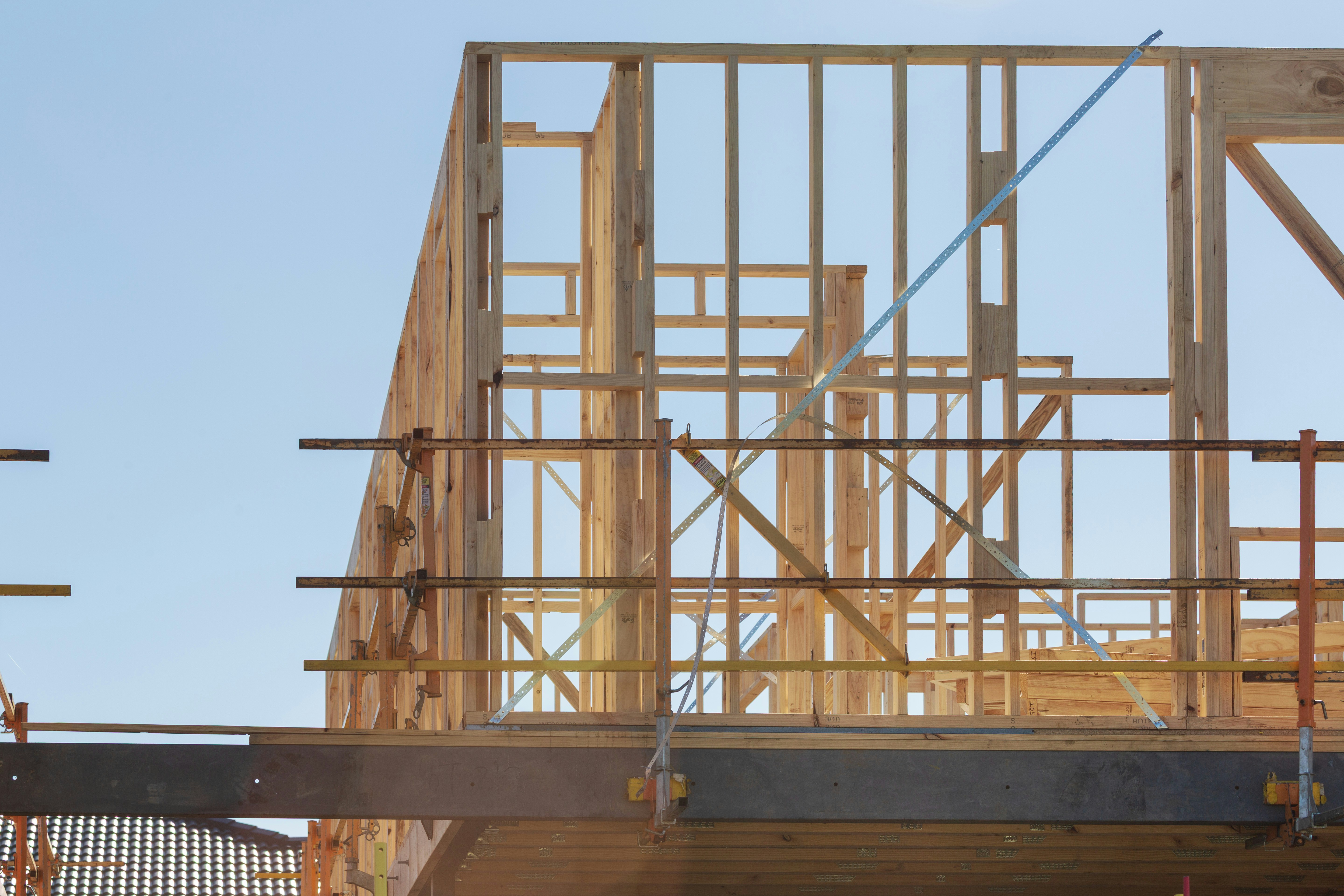 Framed Skeleton: Wooden Construction Rising Against Clear Sky