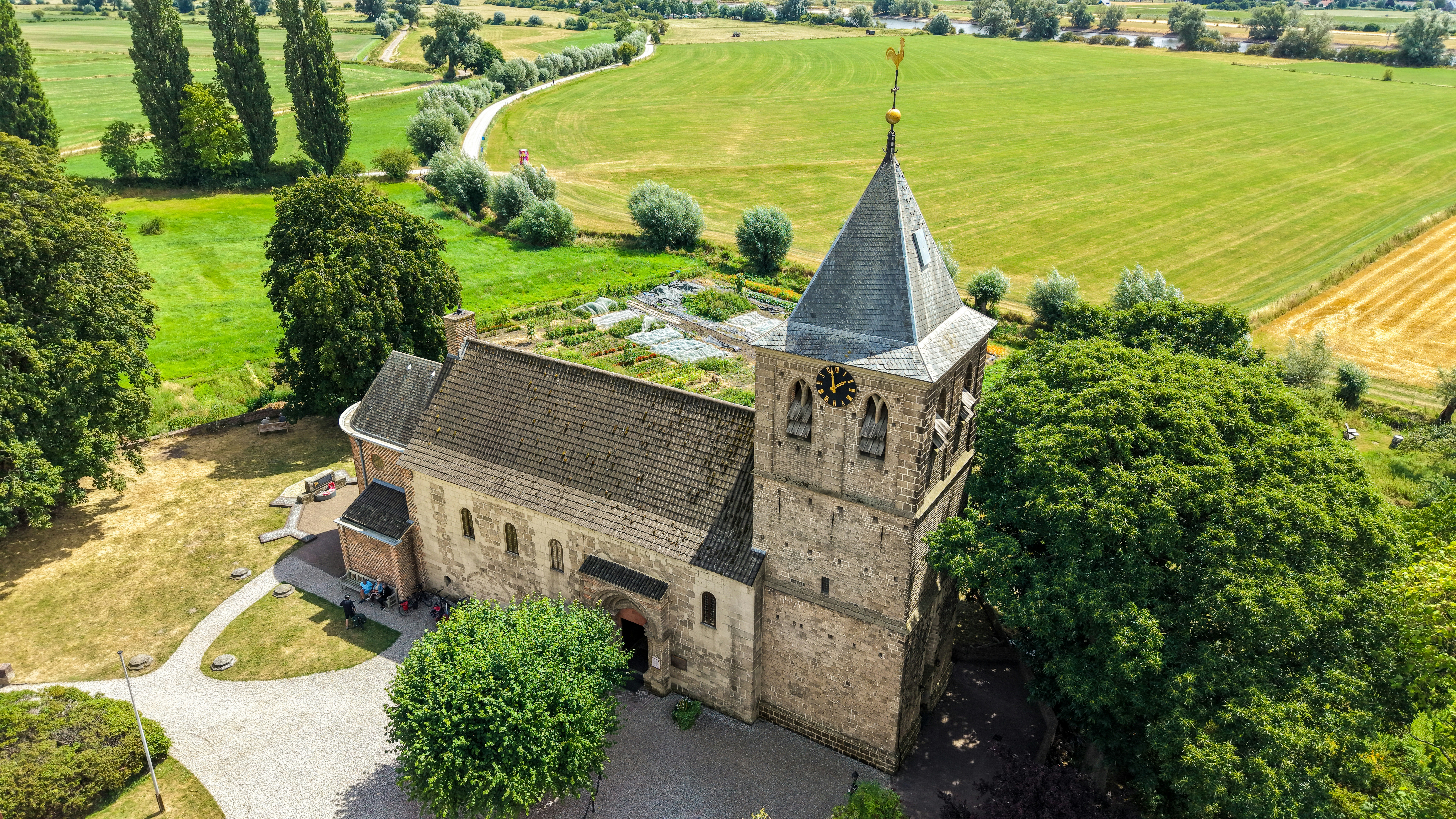 Stone Chapel Amid Rolling Fields: A Quiet Aerial over a Village Church
