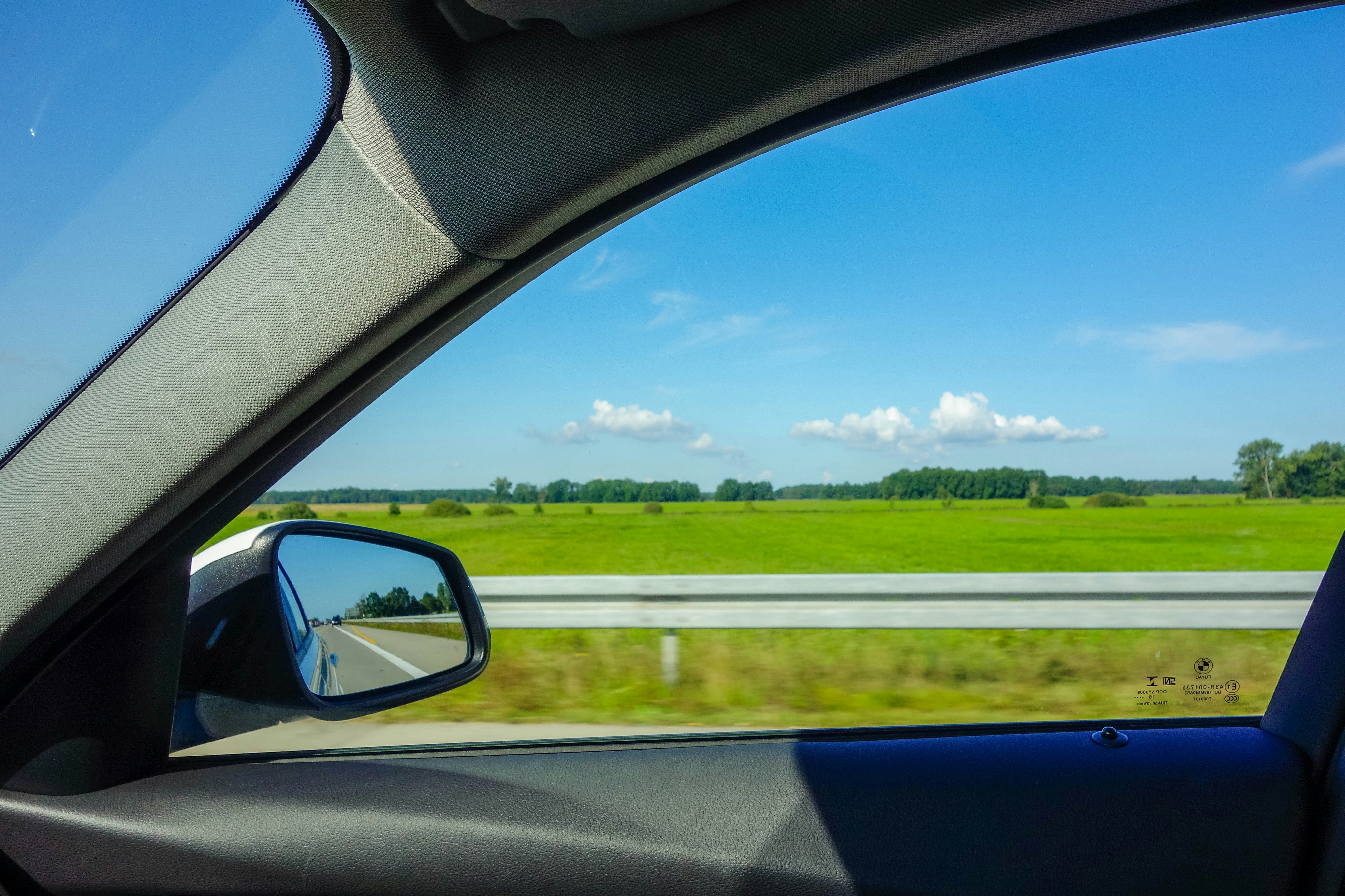Vista Through the Car Window: Open Road, Green Fields, and a Quiet Drive