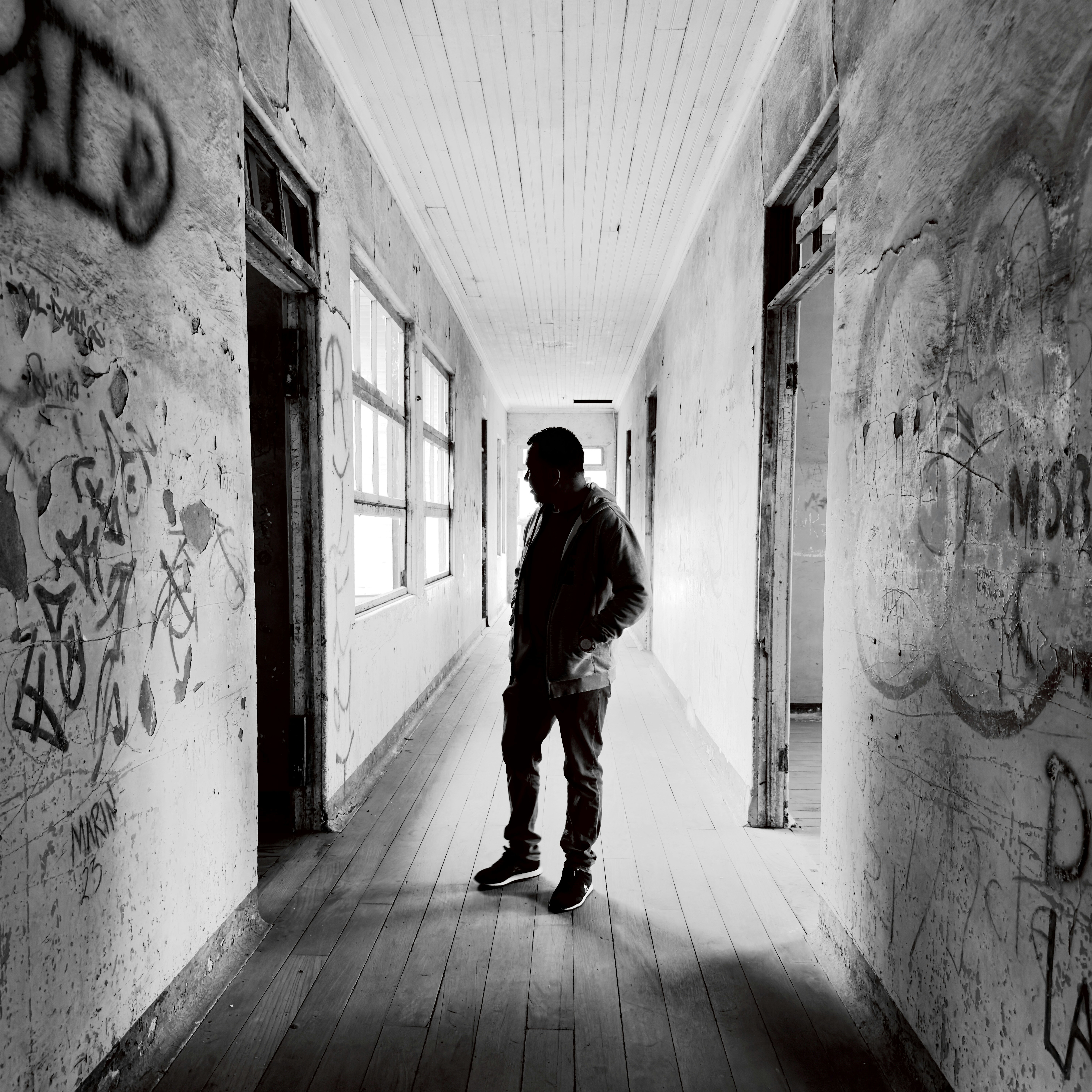 Hallway Silence: A Lone Figure in Grayscale Echoes