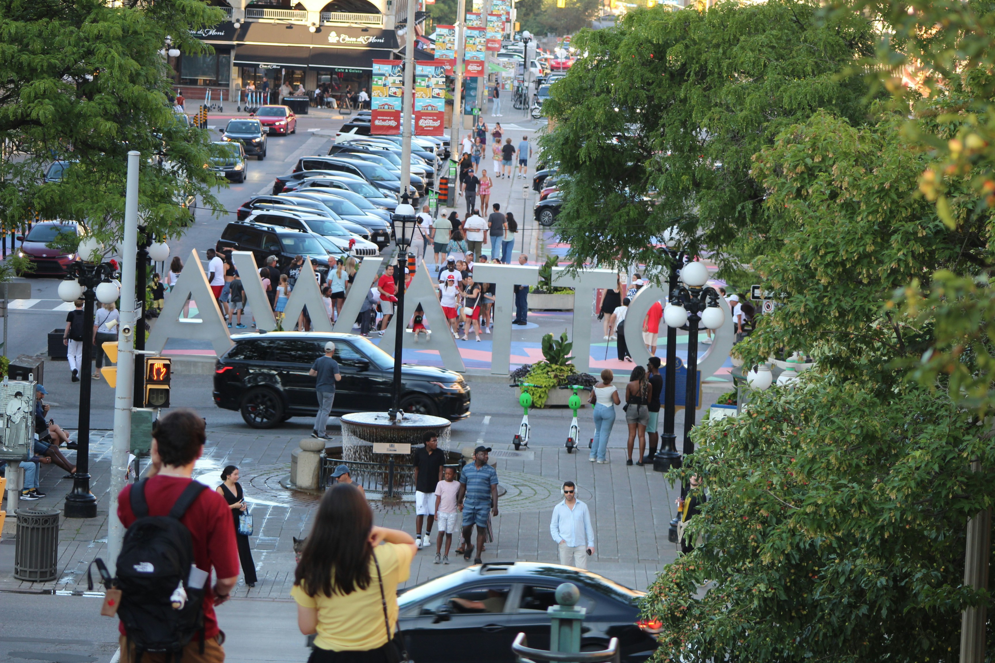 Crowded Main Street Descent: A City Pedestrian Corridor Framed by Trees