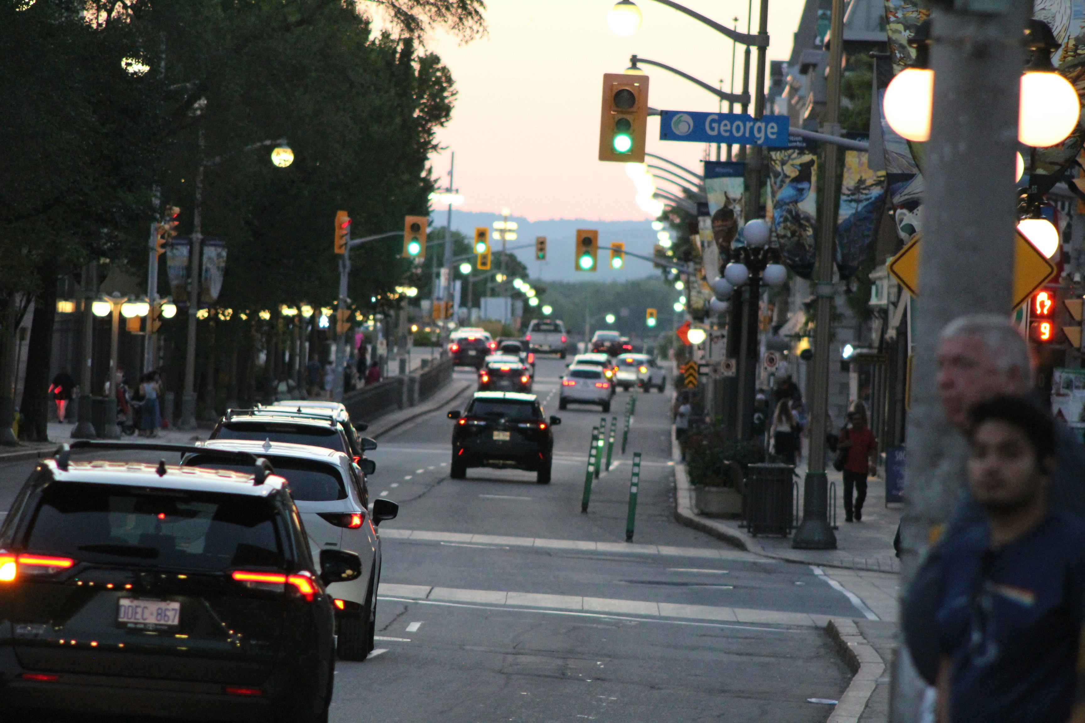 Cars driving on a city street at twilight.