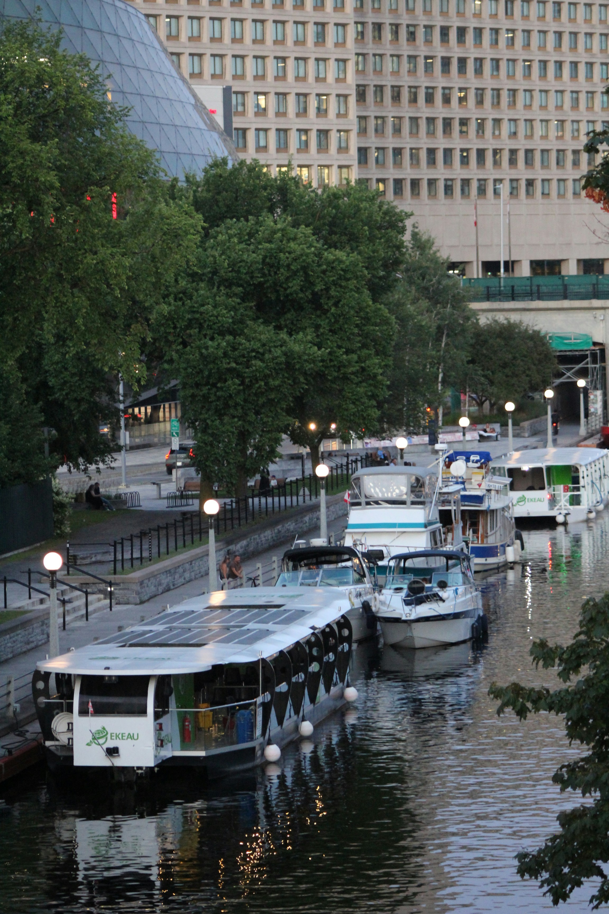 Docked Boats in a City Canal Under a Modern Urban Backdrop