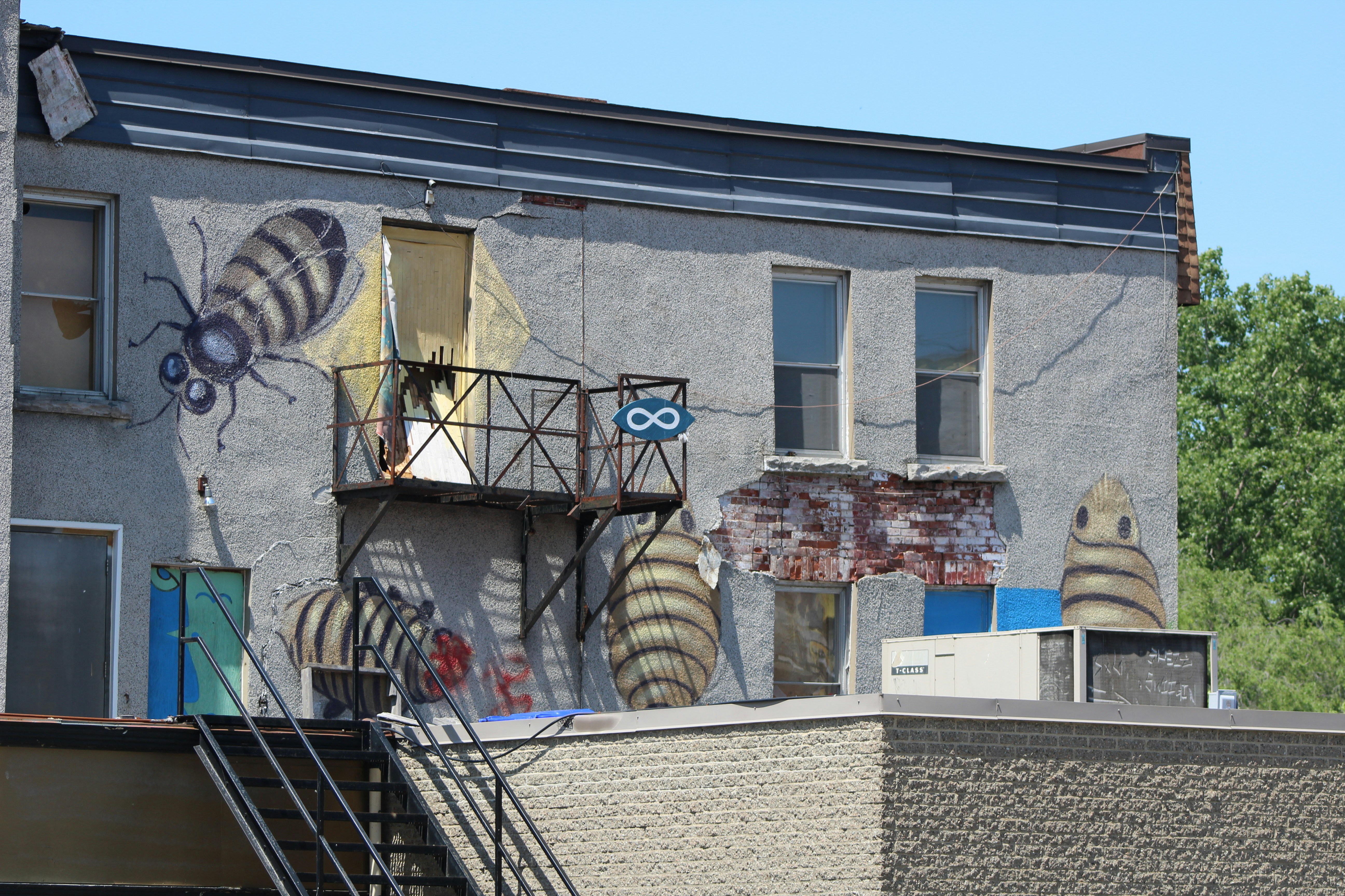 Bee Monuments: A Graffitied Factory Facade with Giant Insects