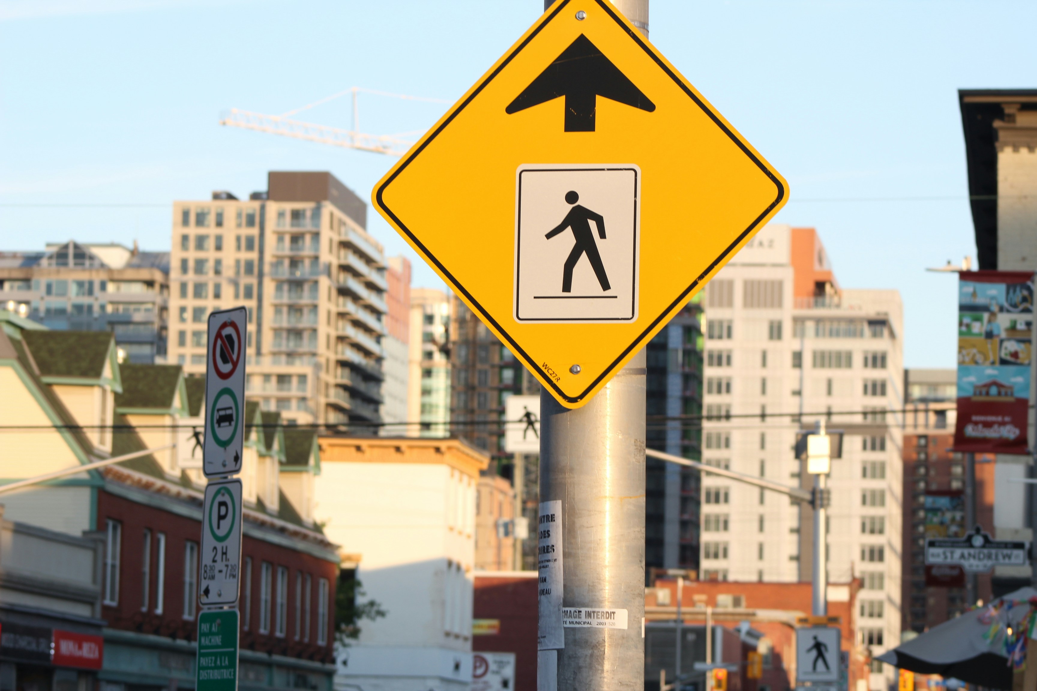 Urban Pedestrian Crossing Sign Framed by Cityscape