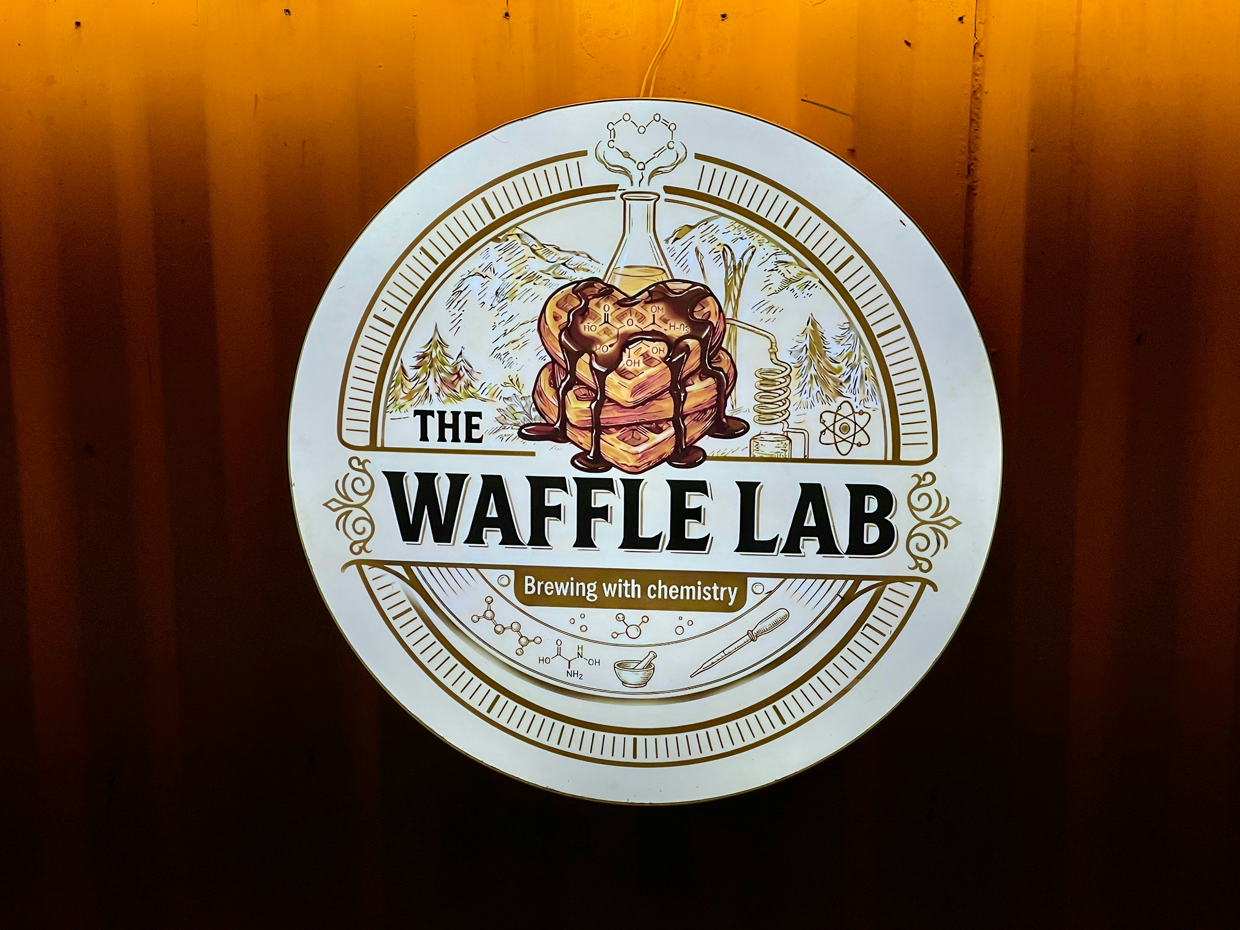 Circular Signage of The Waffle Lab: Toasty Crest on Copper Backdrop