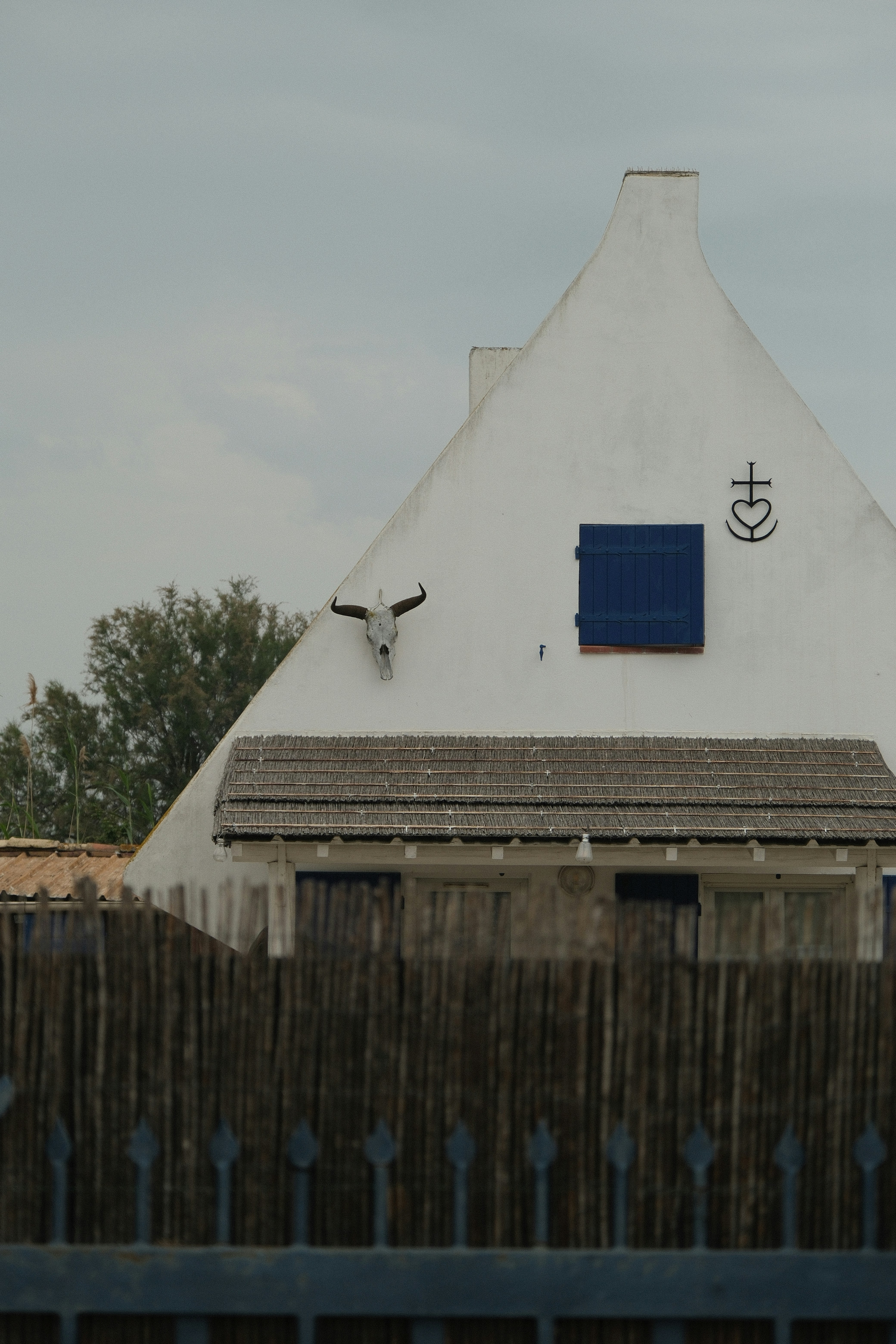 Bull Skull Above a White Facade: A Quiet Rural Gable