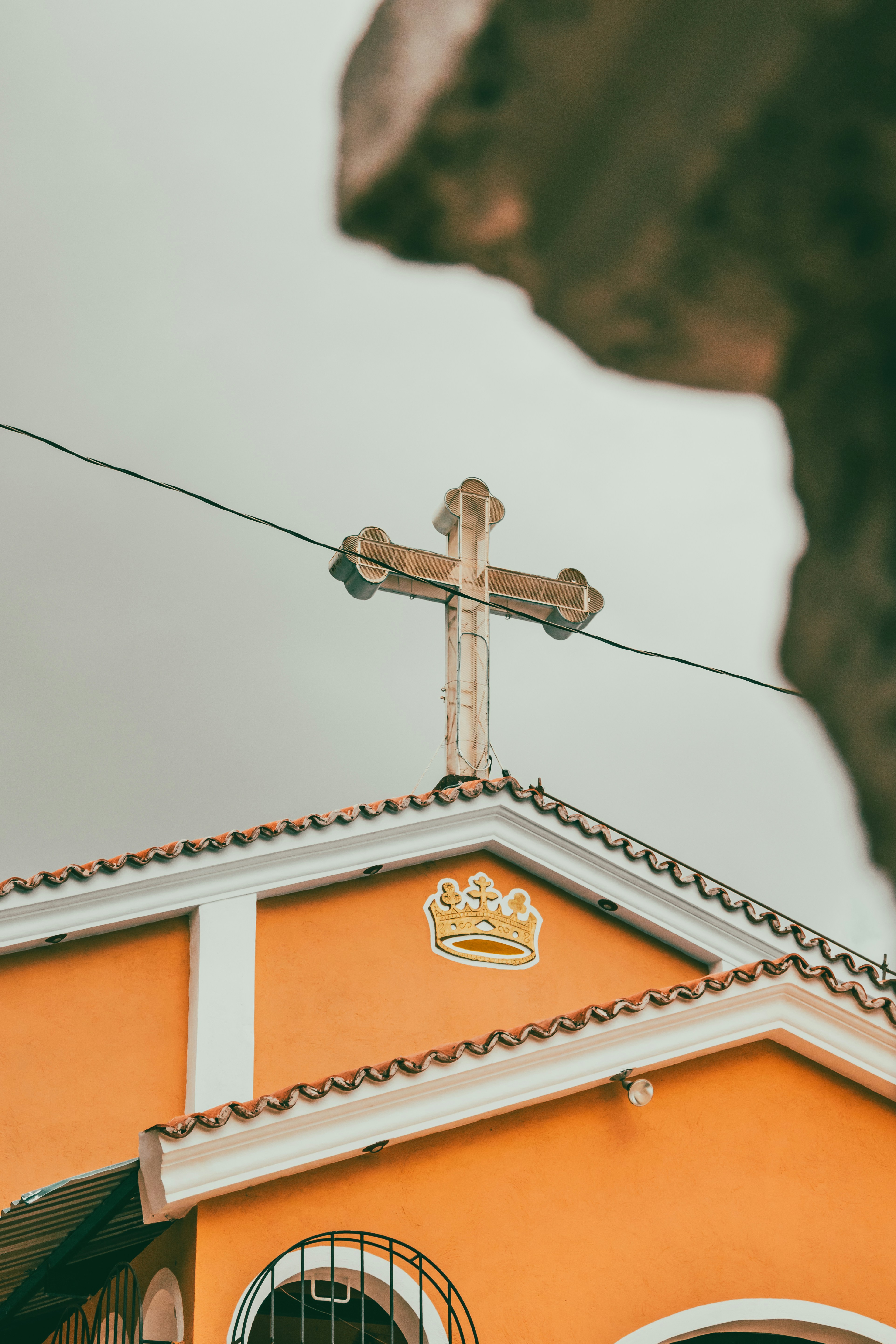 Cross and Crown Over Orange Tiles