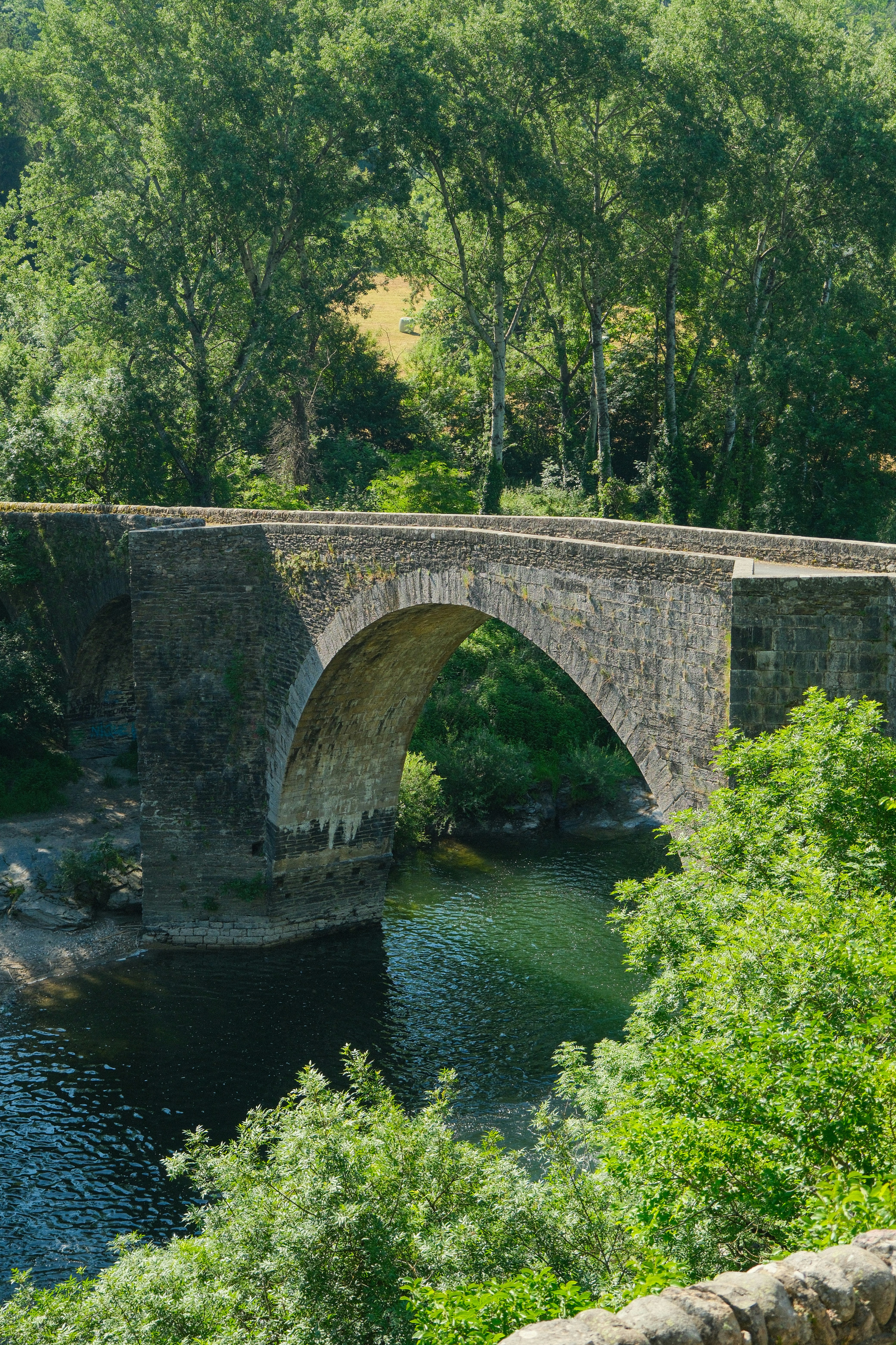 Stone Arc over Quiet River: Morning Light on an Ancient Bridge