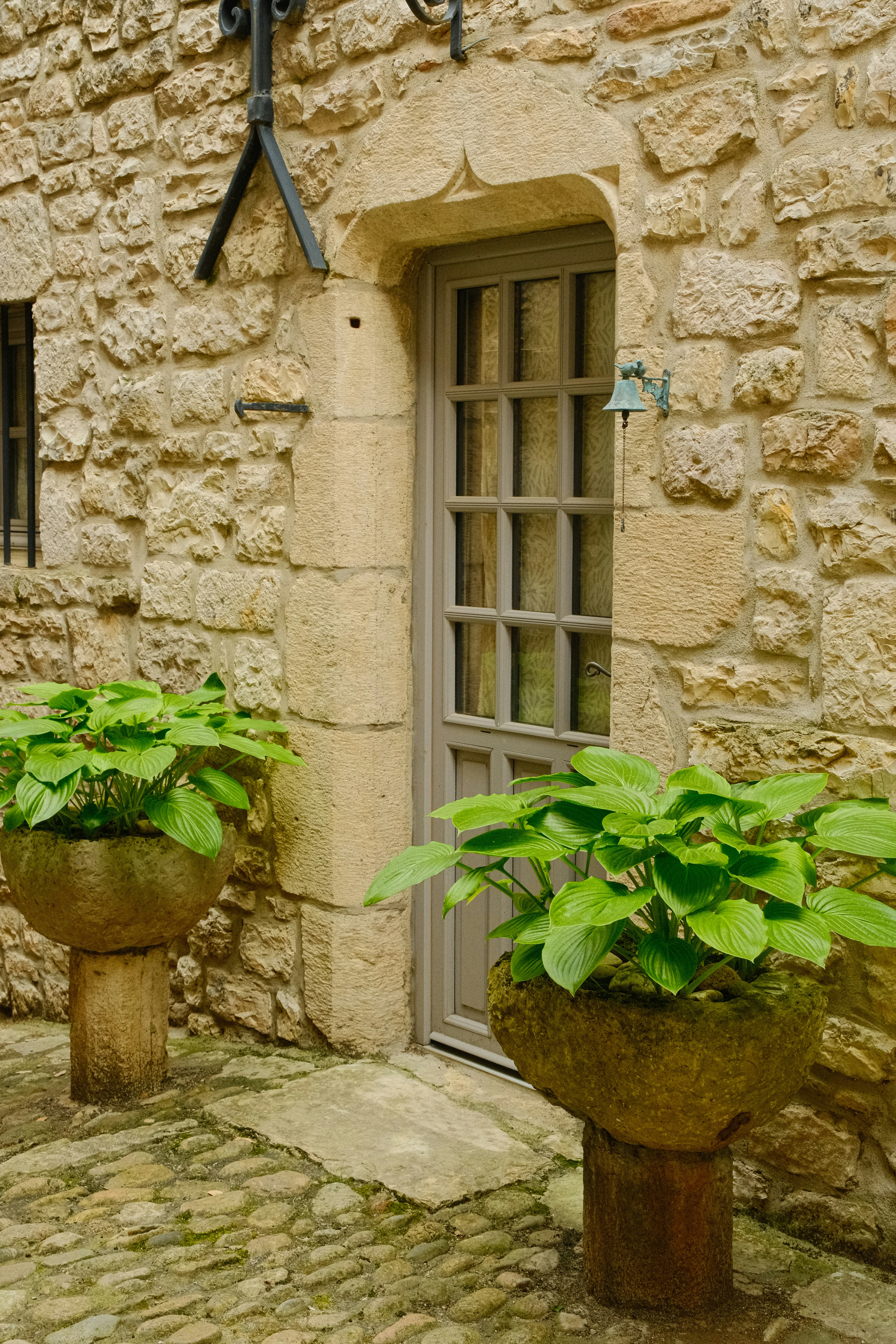 Stone doorway with potted greenery framing a quiet courtyard entrance
