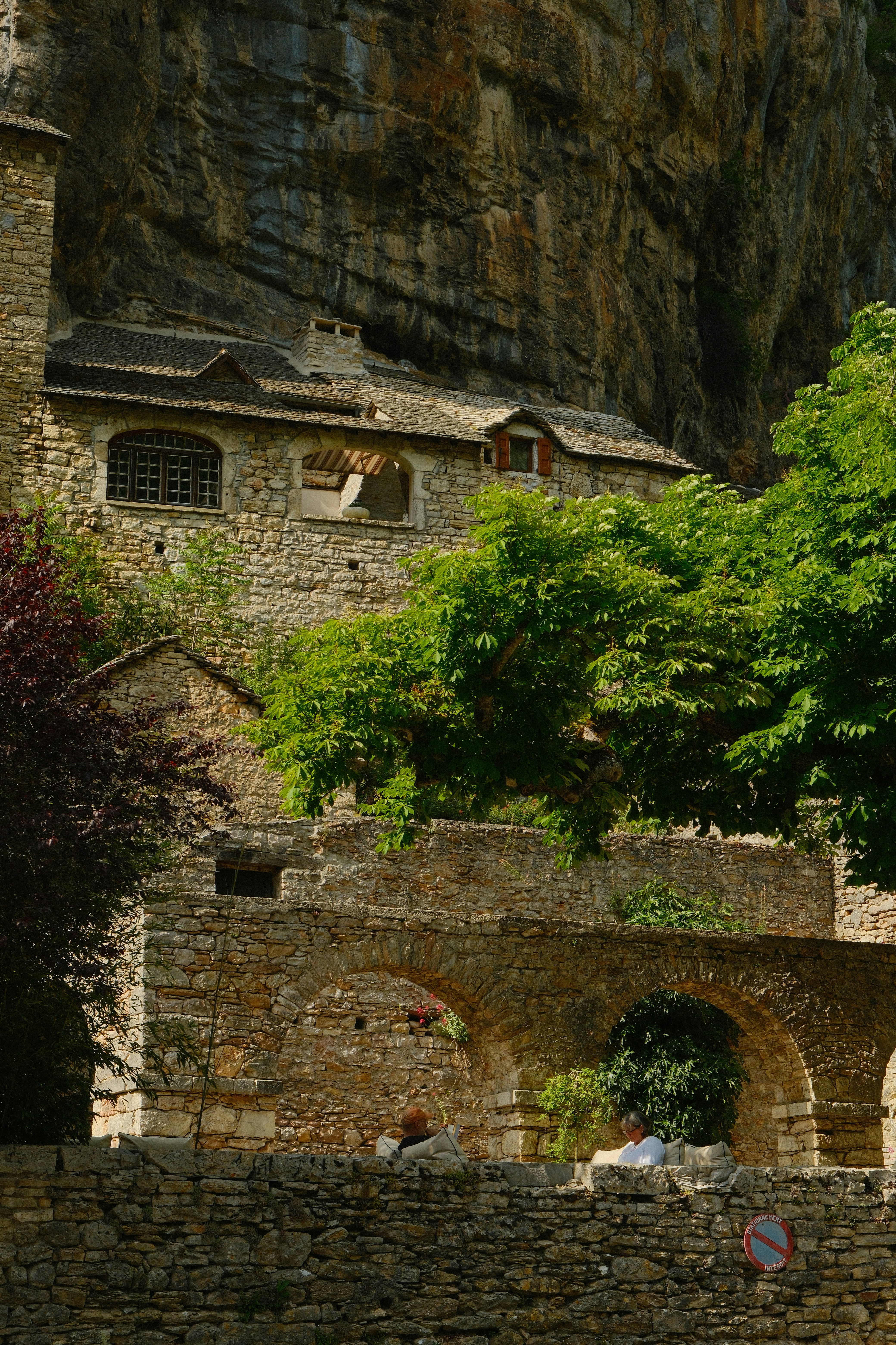 Stone Courtyard Beneath a Cliff: Verdant Balcony and Arched Terrace