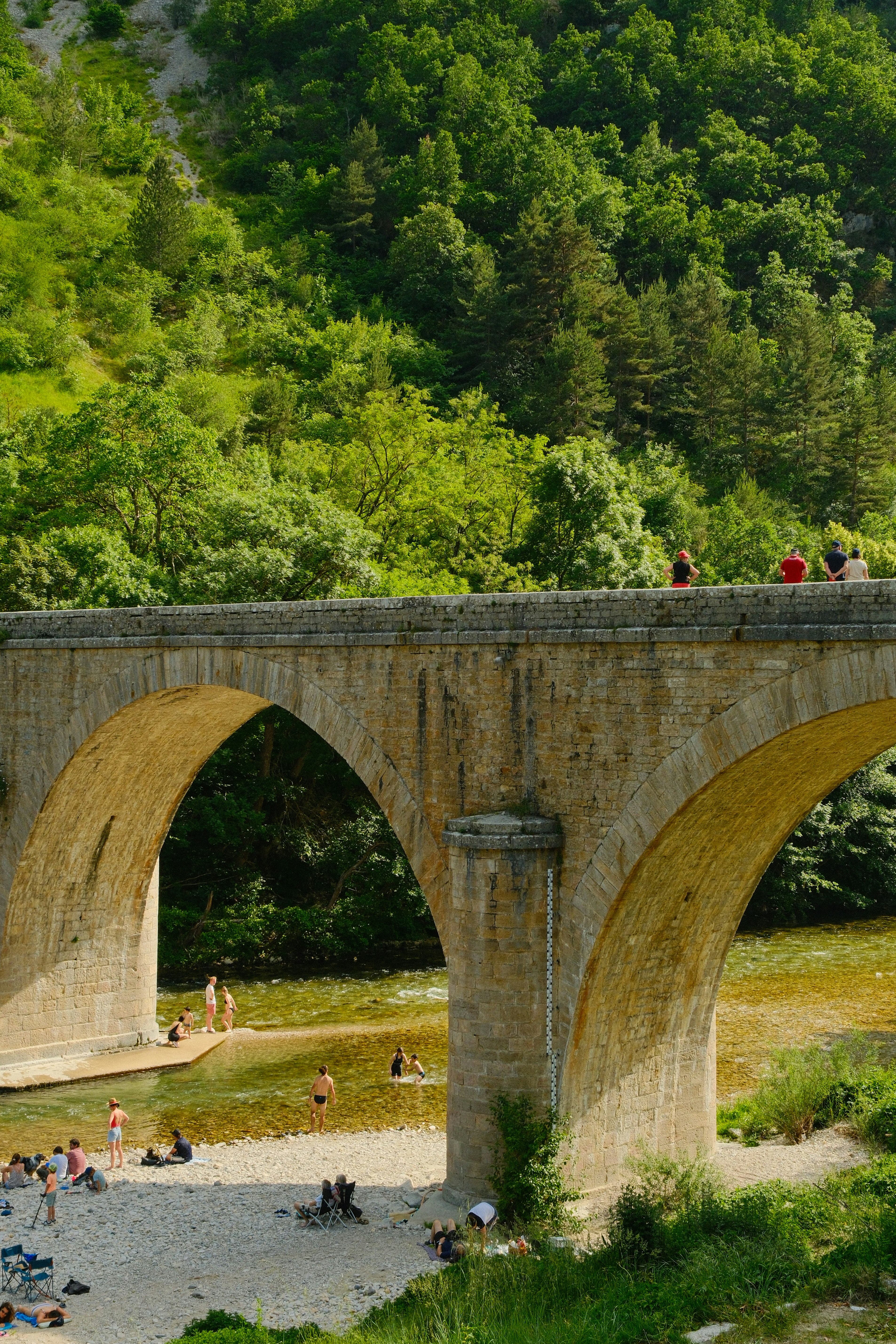 Stone Arc Bridge Over a Shaded Riverbank