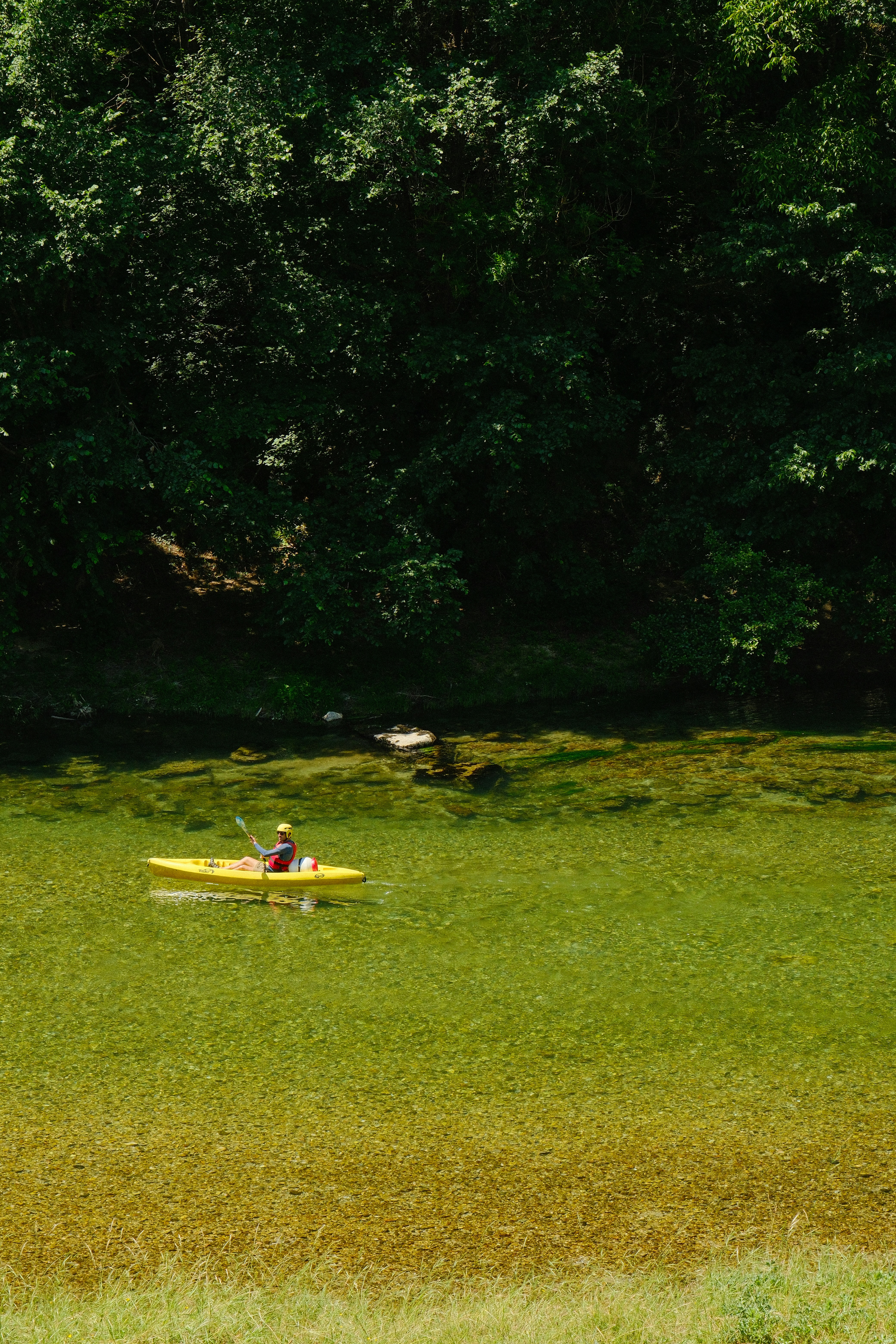 Yellow Kayak Drifter on Sunlit River
