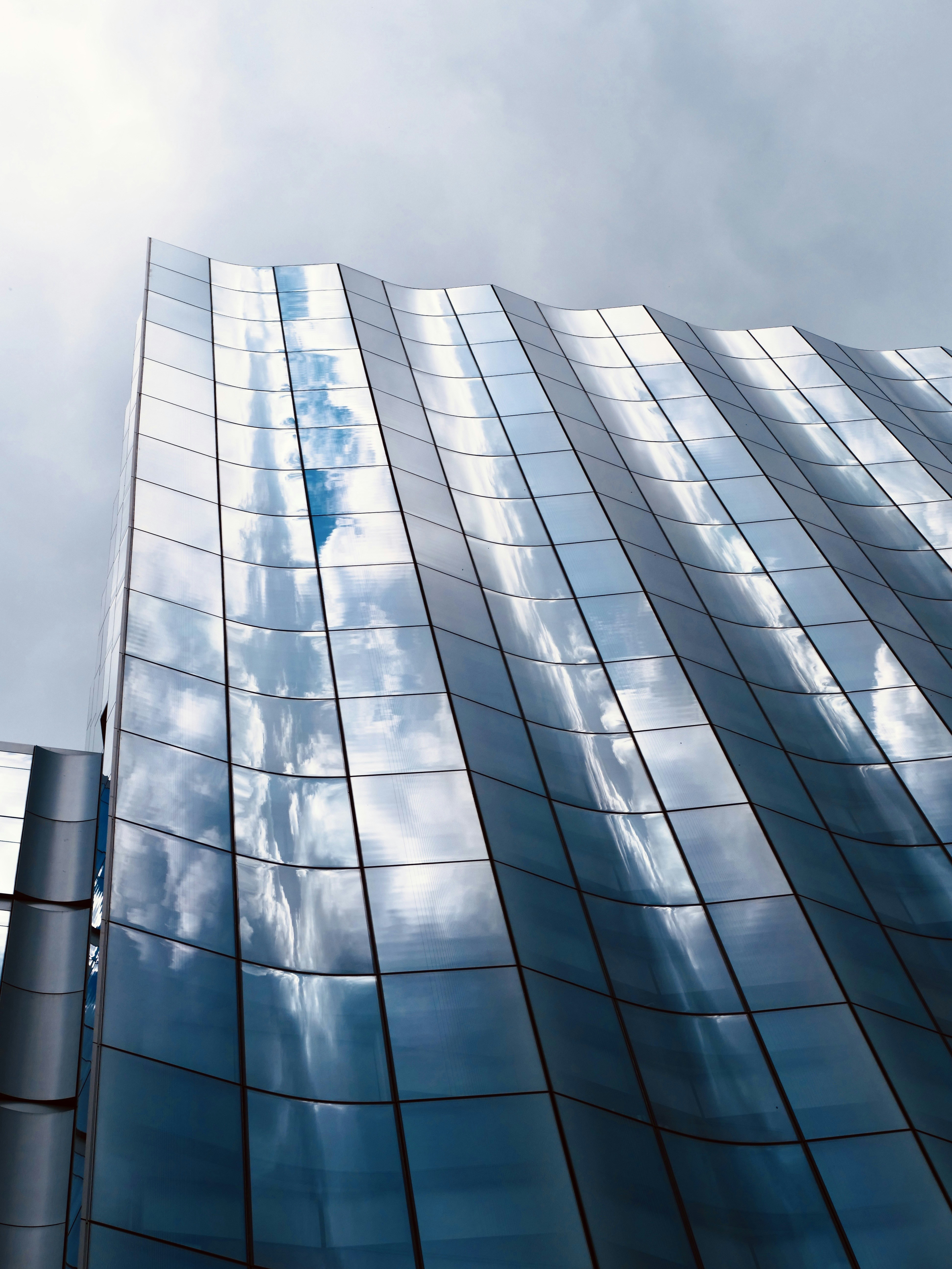 Prismatic Facade: Reflections on a Sky-Blue Steel Wave