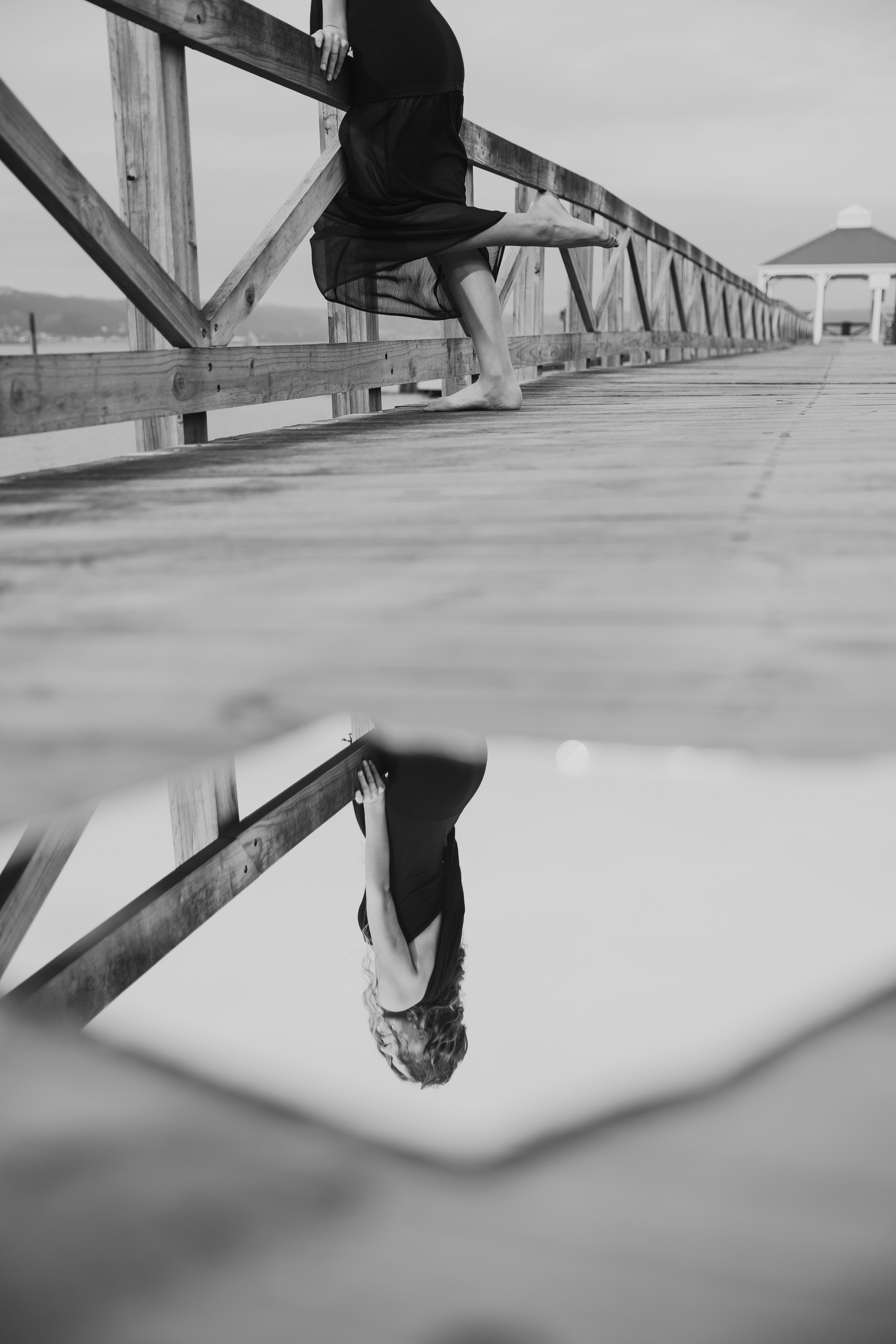 Echoes on the Pier: A Silhouette and its Reflection