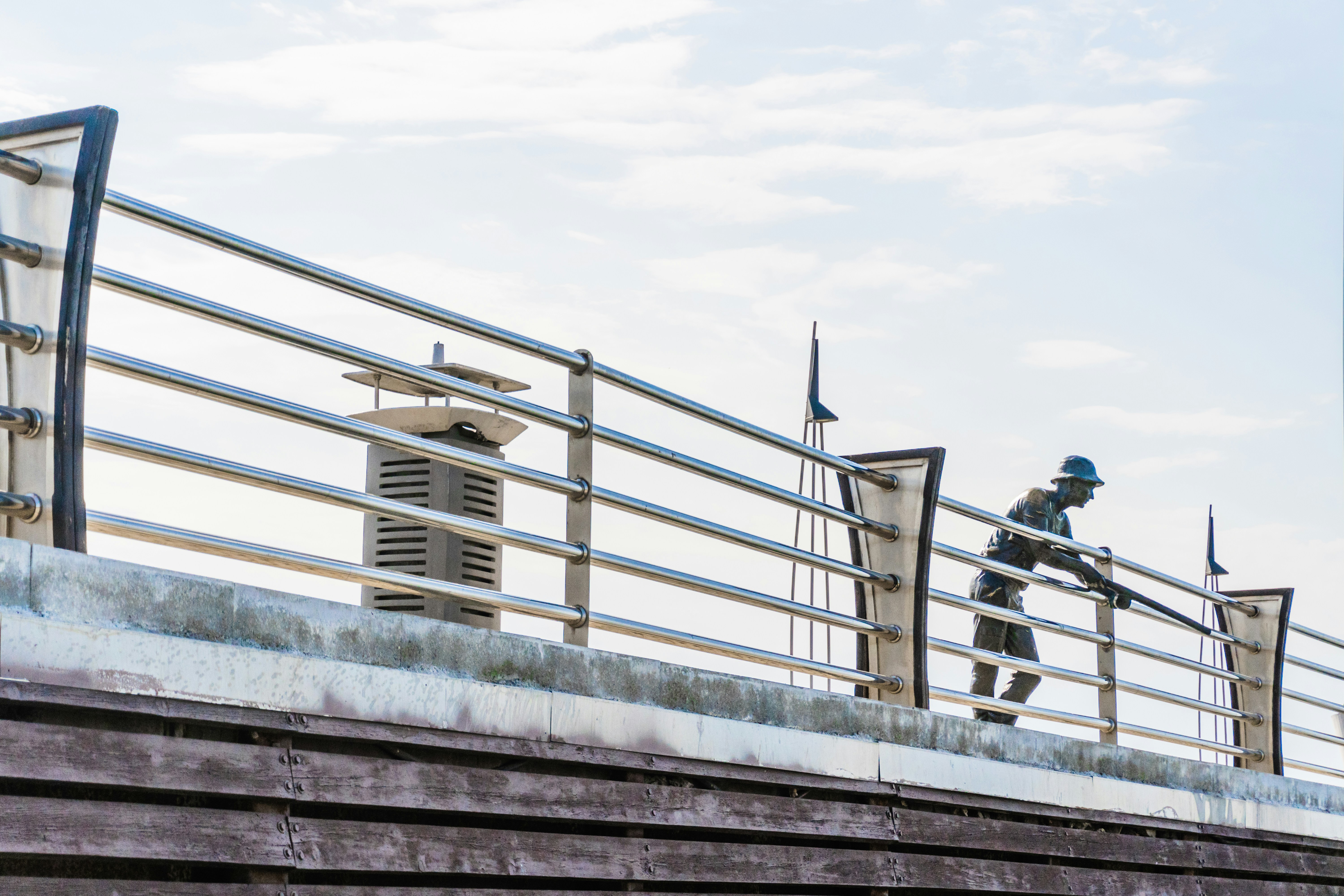 Runner on a bridge: silhouette against rails and sky