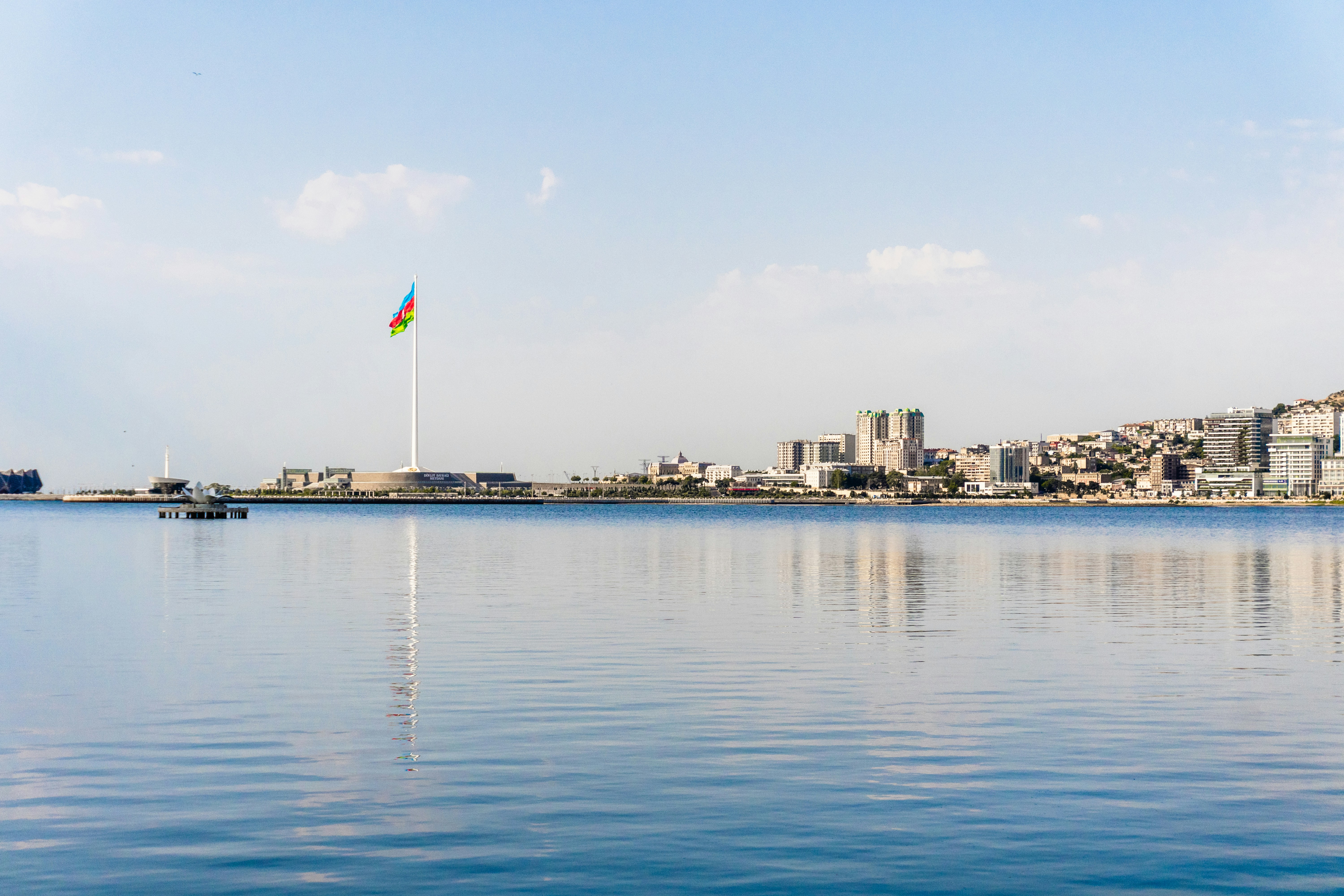 Flagpole at the Waterfront: Calm Sea and Cityline