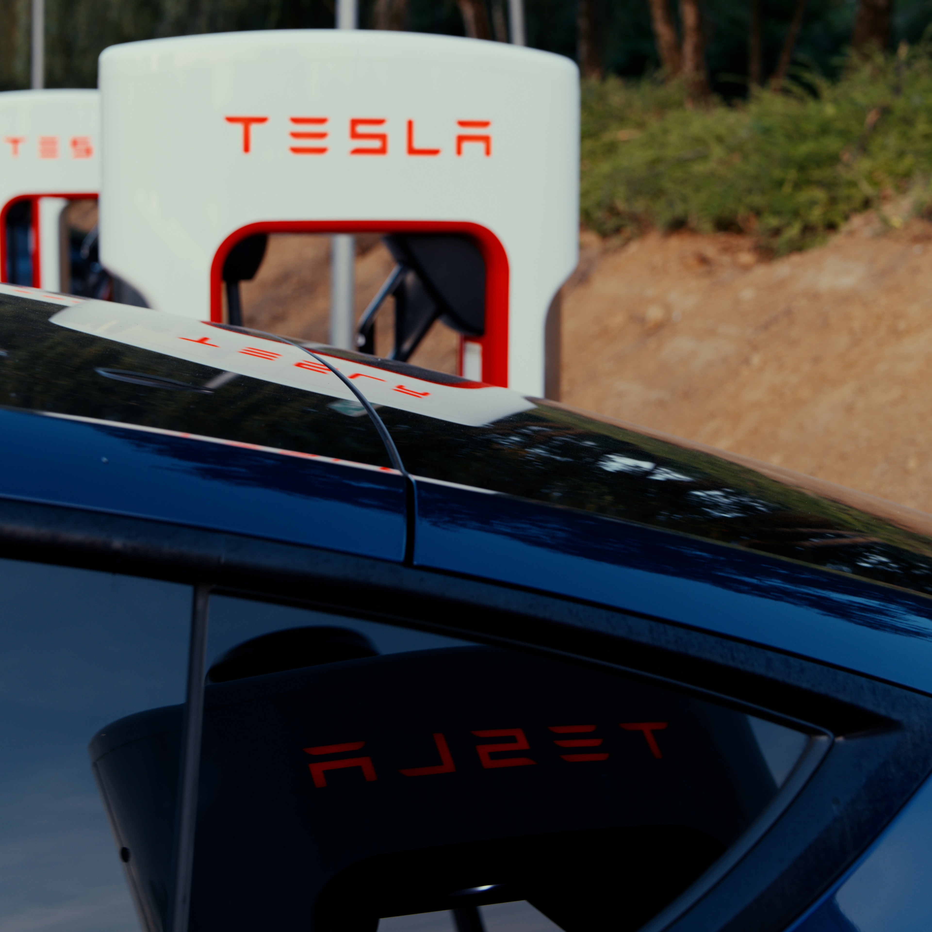 Tesla at the Charge: Close-Up of a Shiny Vehicle by the Fast Charger
