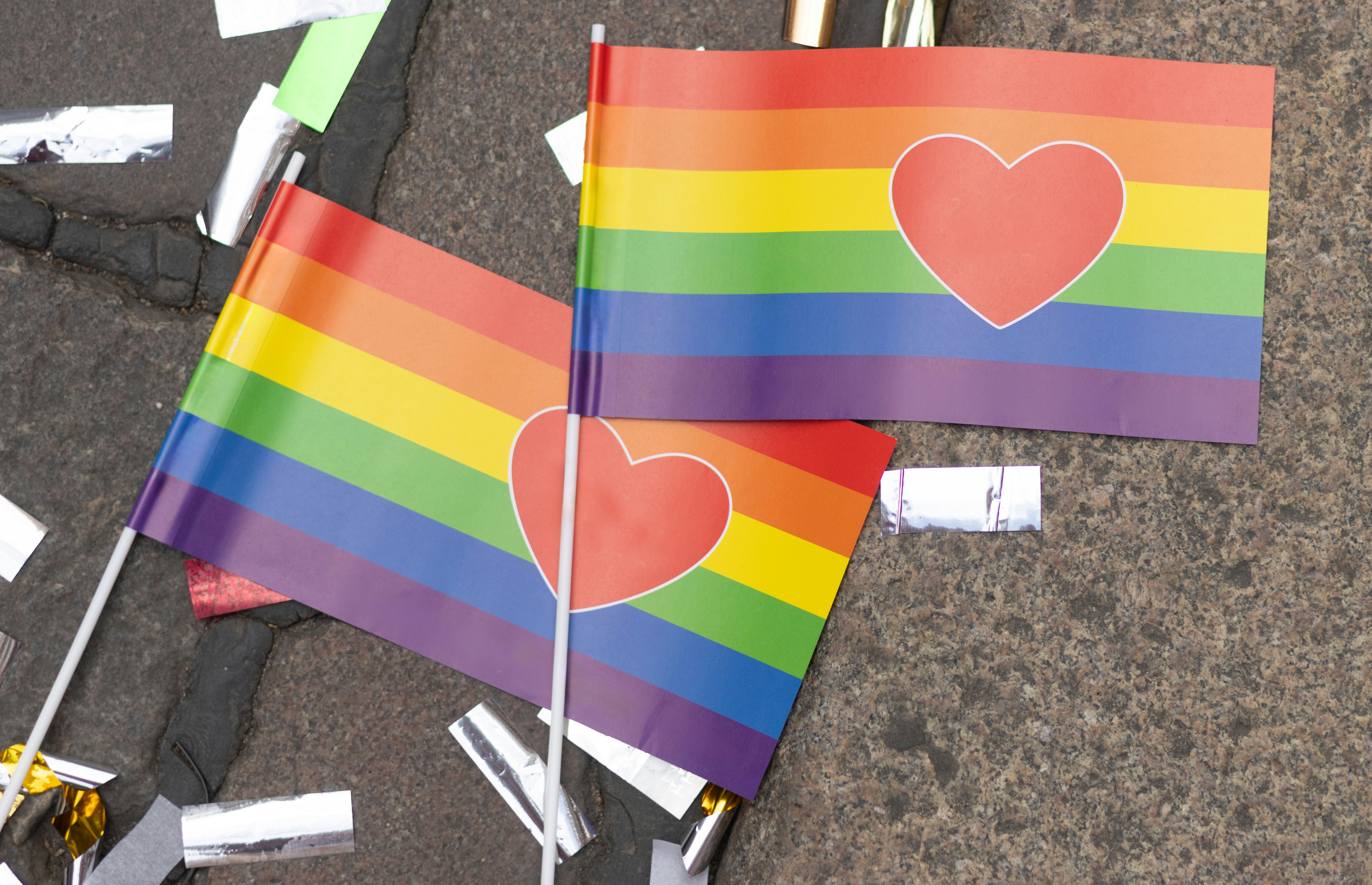 Rainbow Hearts on Street: Flags Amid Shimmering Debris