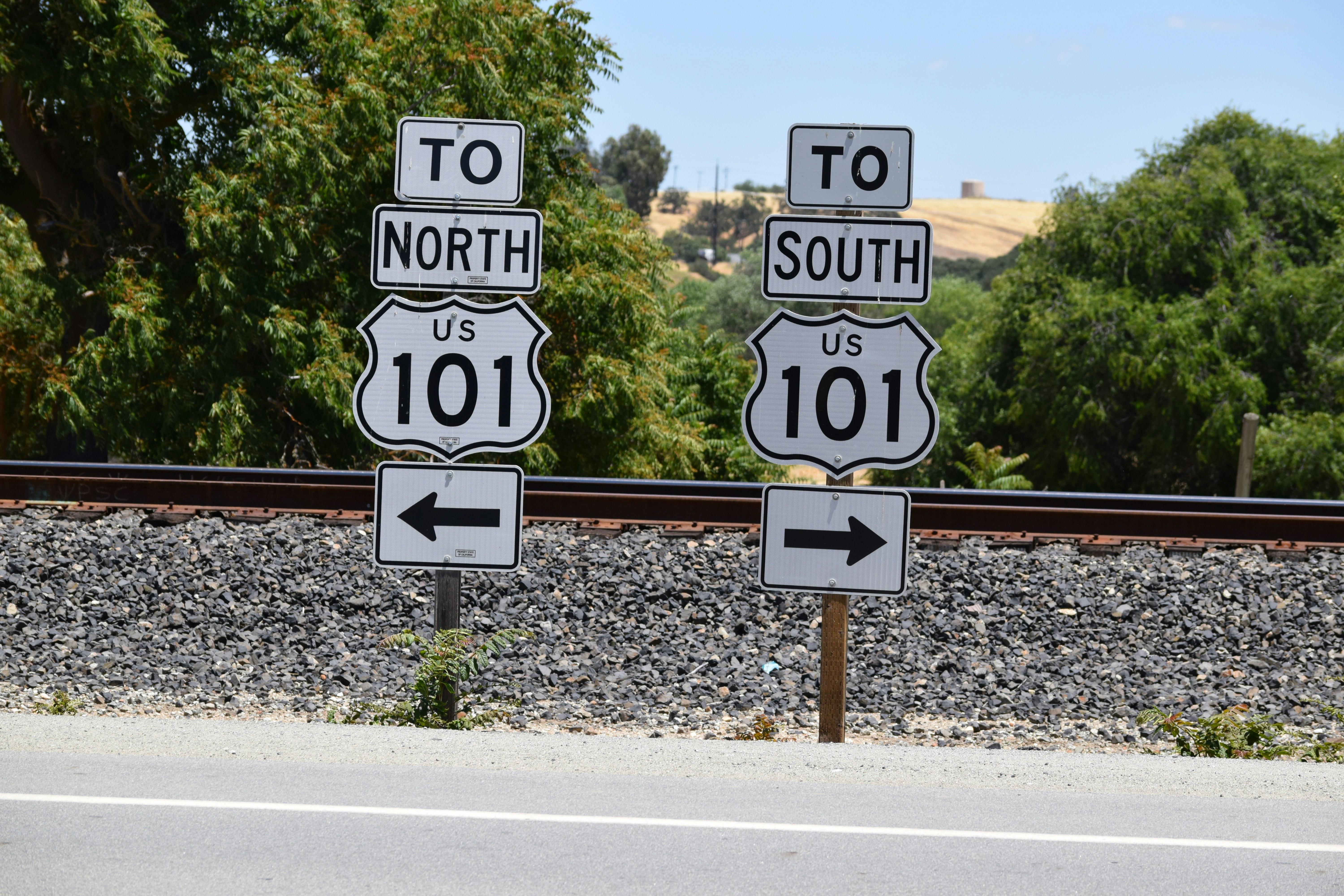 Split Routes: Highway Signs Pointing North and South on a Quiet Riverside