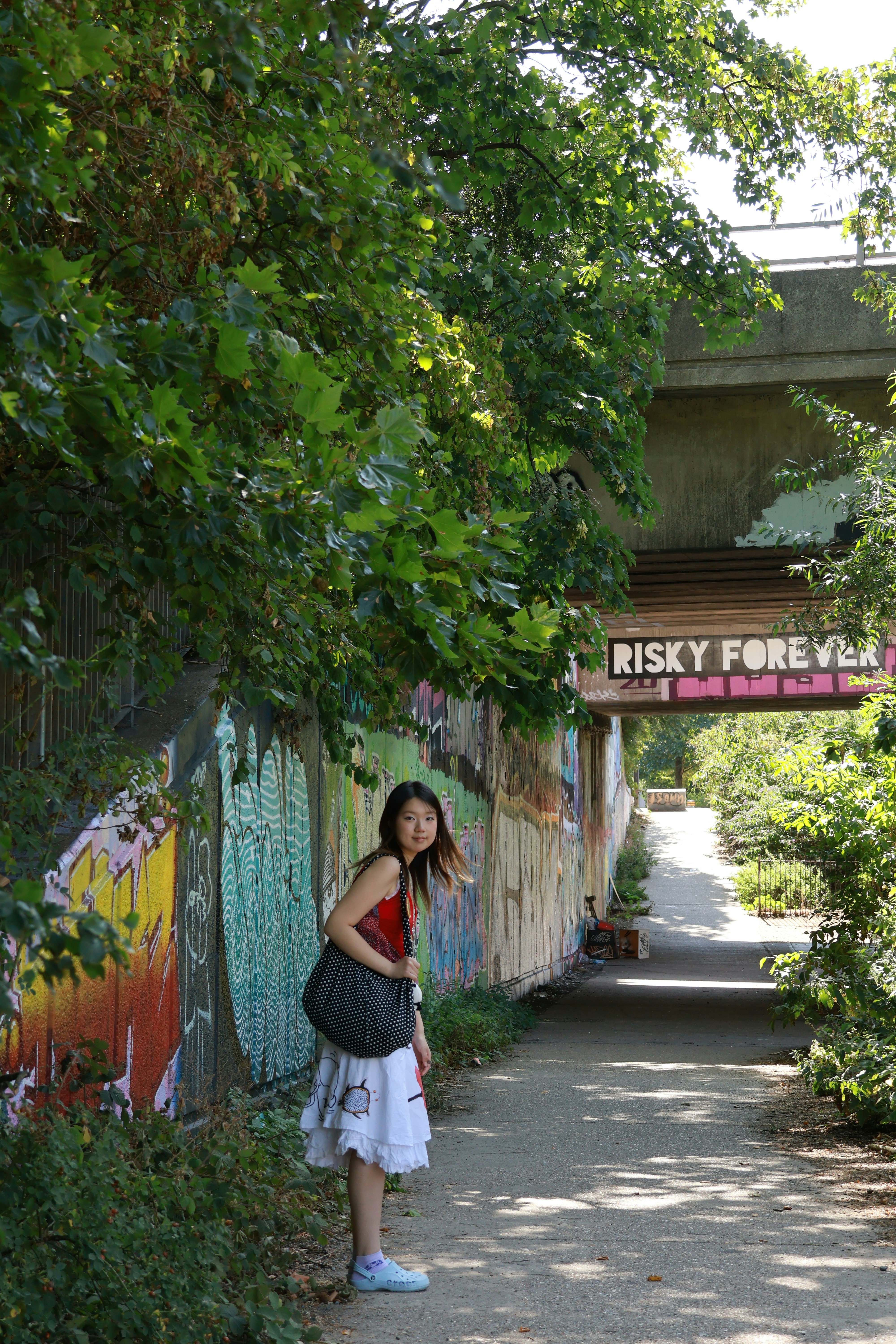 Girl in an Urban Graffiti Alley Under Verdant Shade