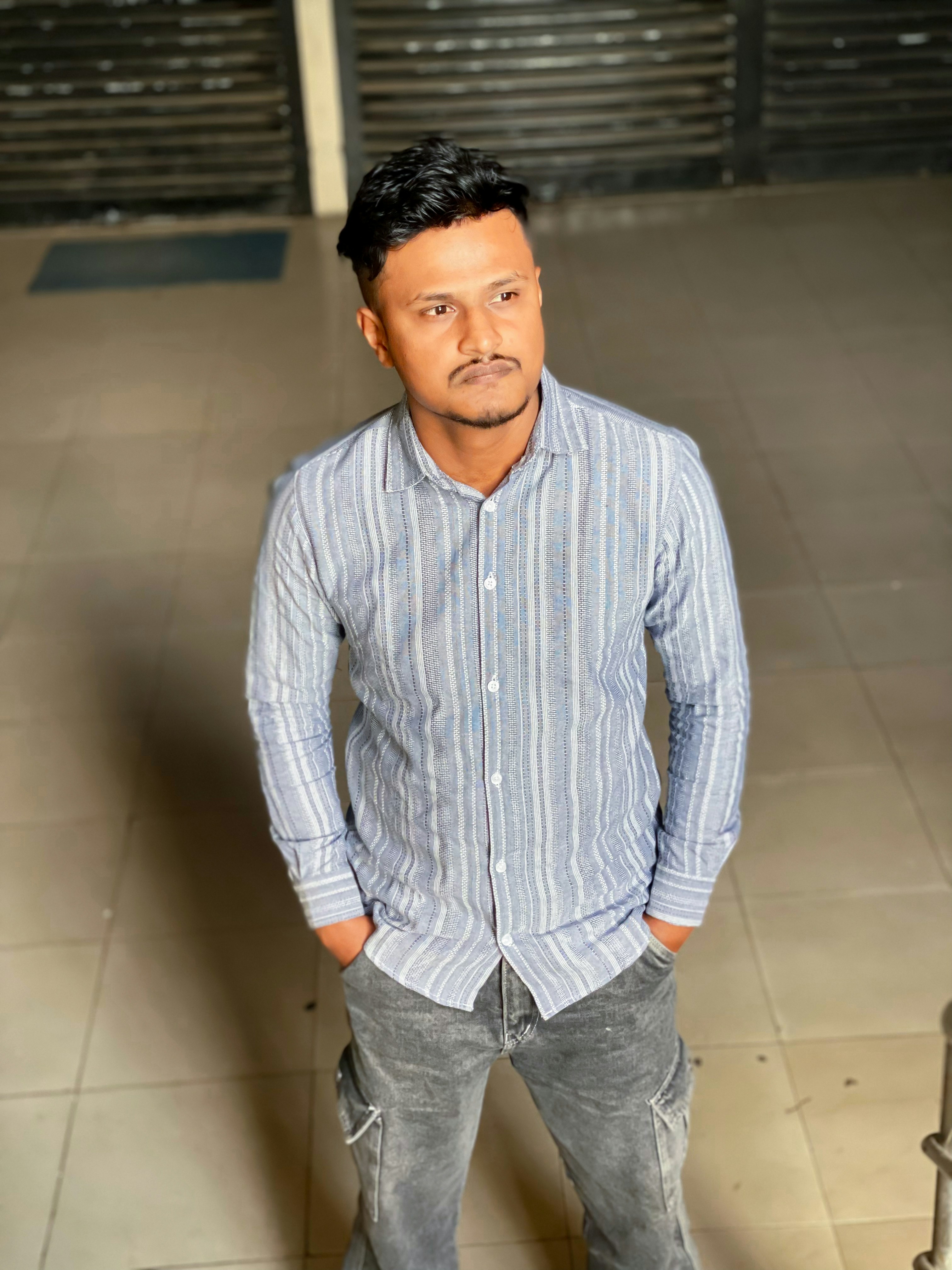 Centered Quiet Confidence: A Man in Striped Shirt in a Quiet Hall
