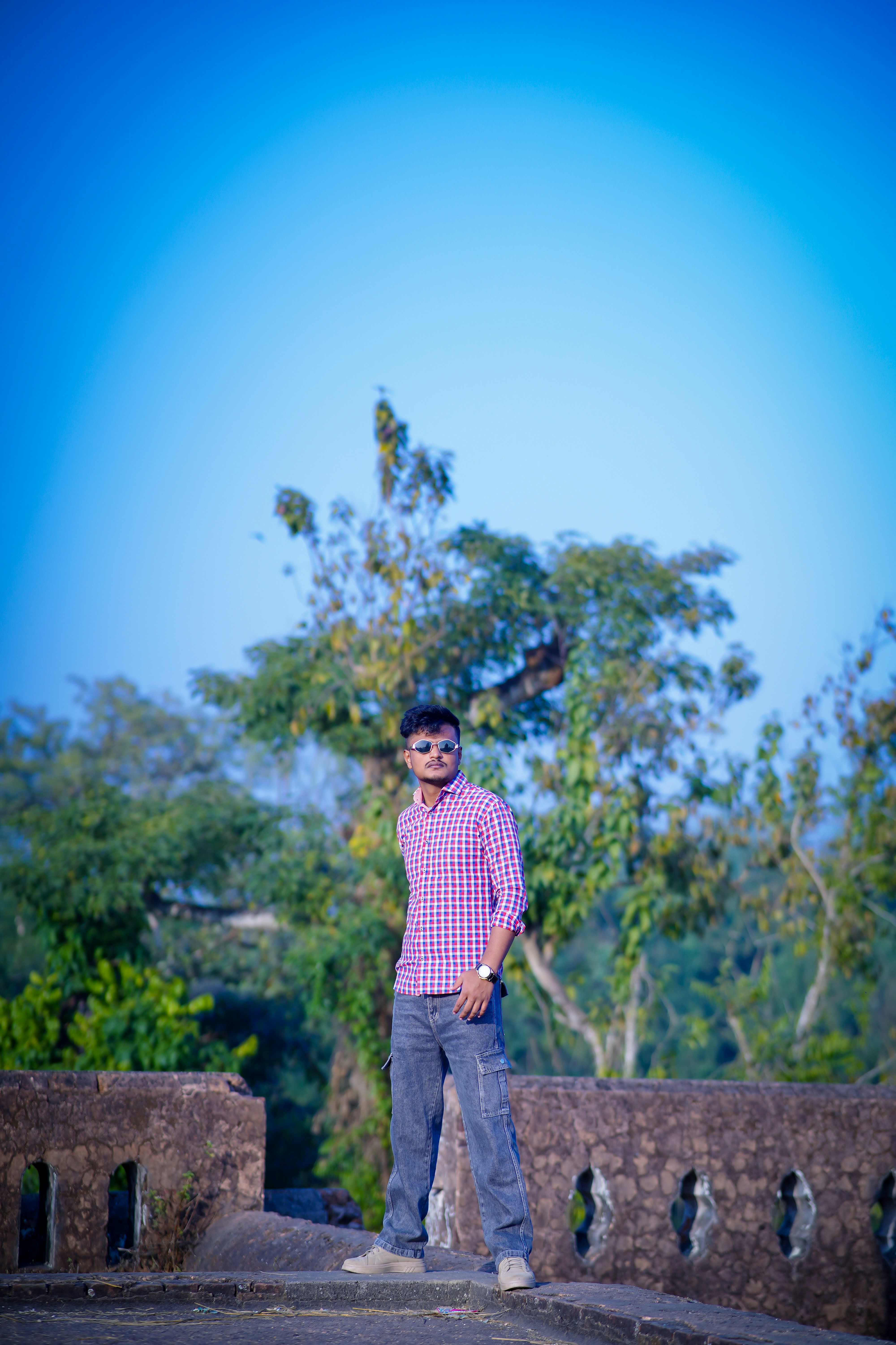 Portrait on the Breezy Bridge: A Casual Stance Beneath a Cerulean Arc