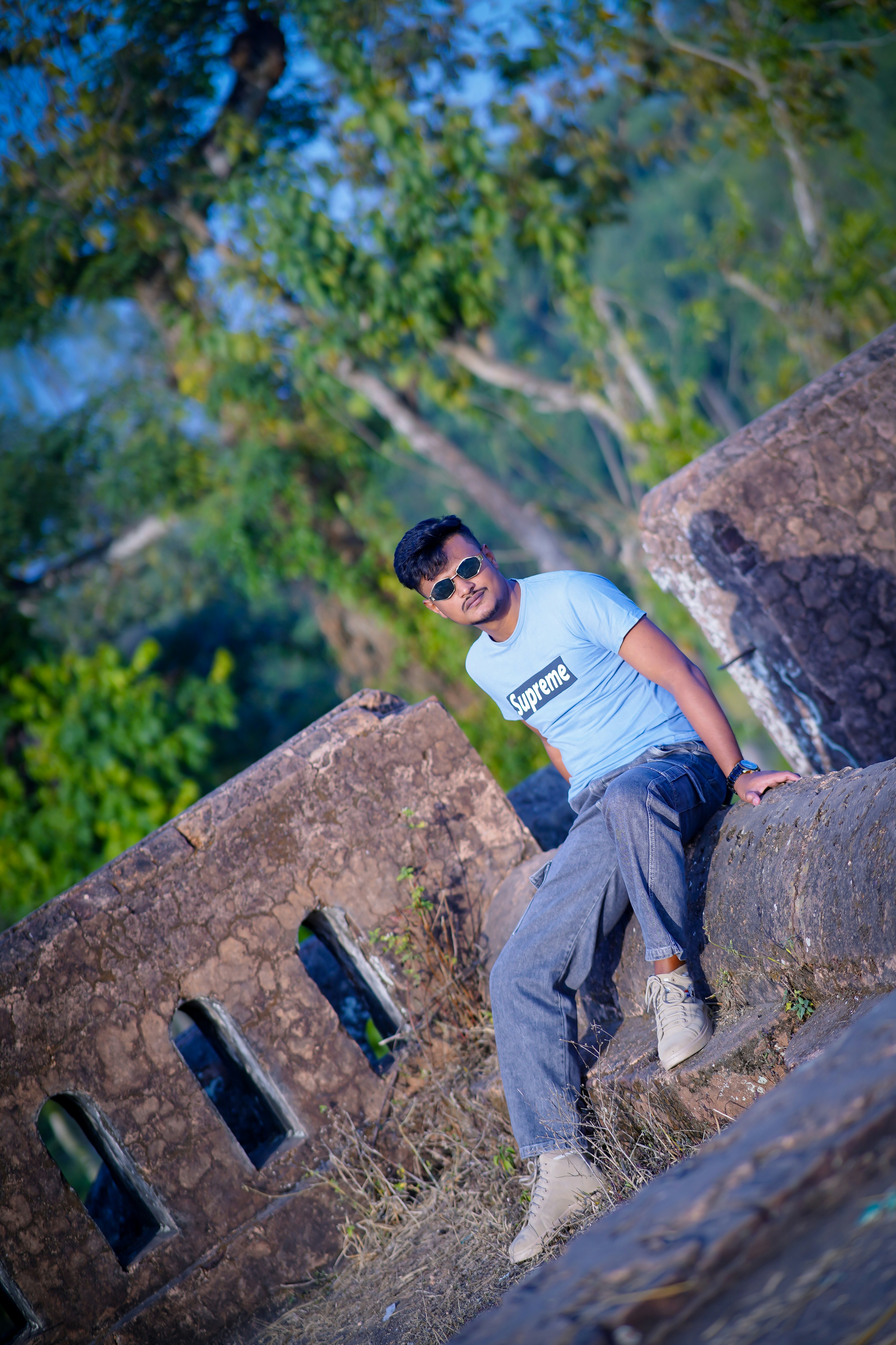 Leaned back on ancient stone, a casual portrait of a rider in pale blue tee