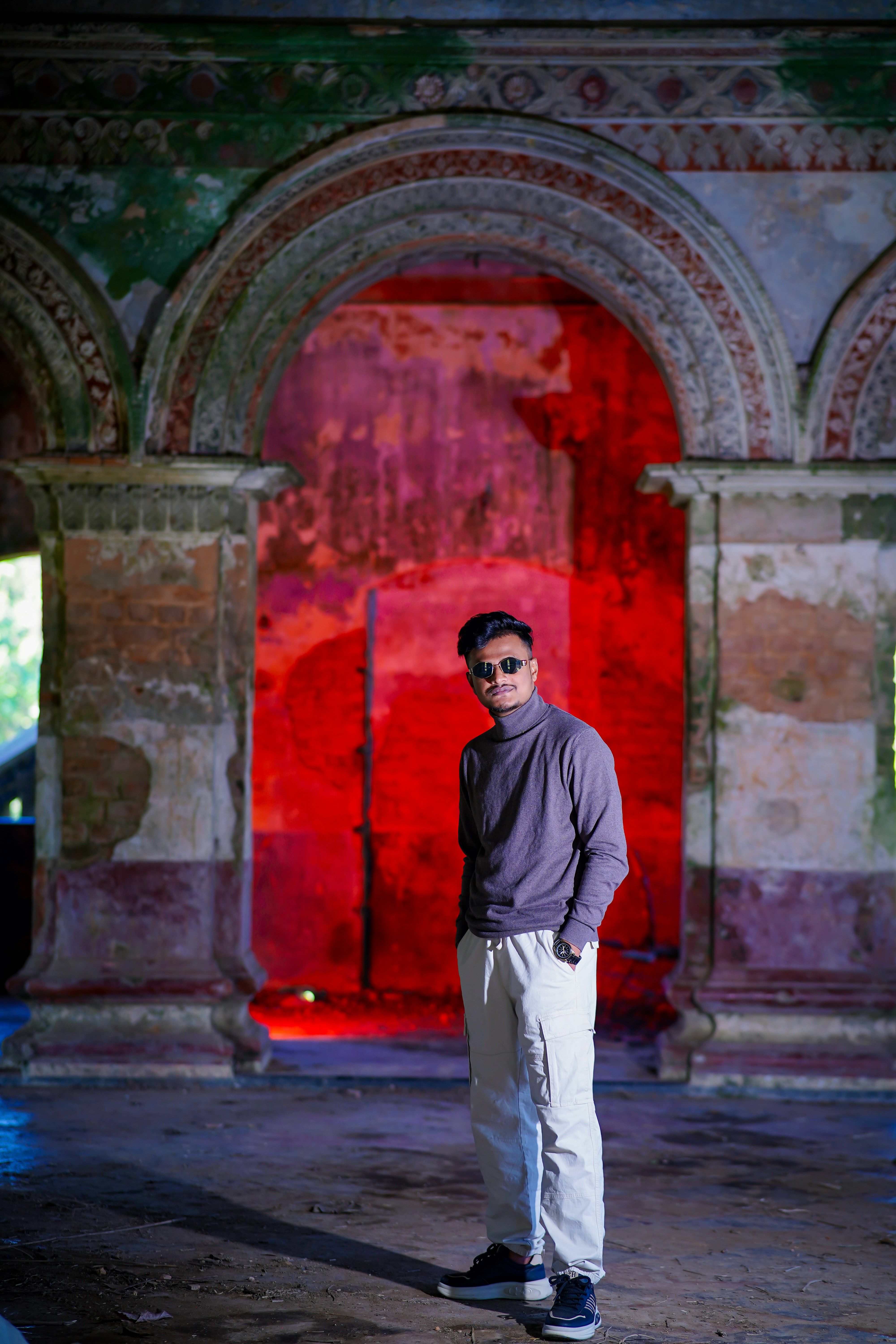 Man in a Purple Turtleneck Stands Before an Arched, Color-Blocked Archway