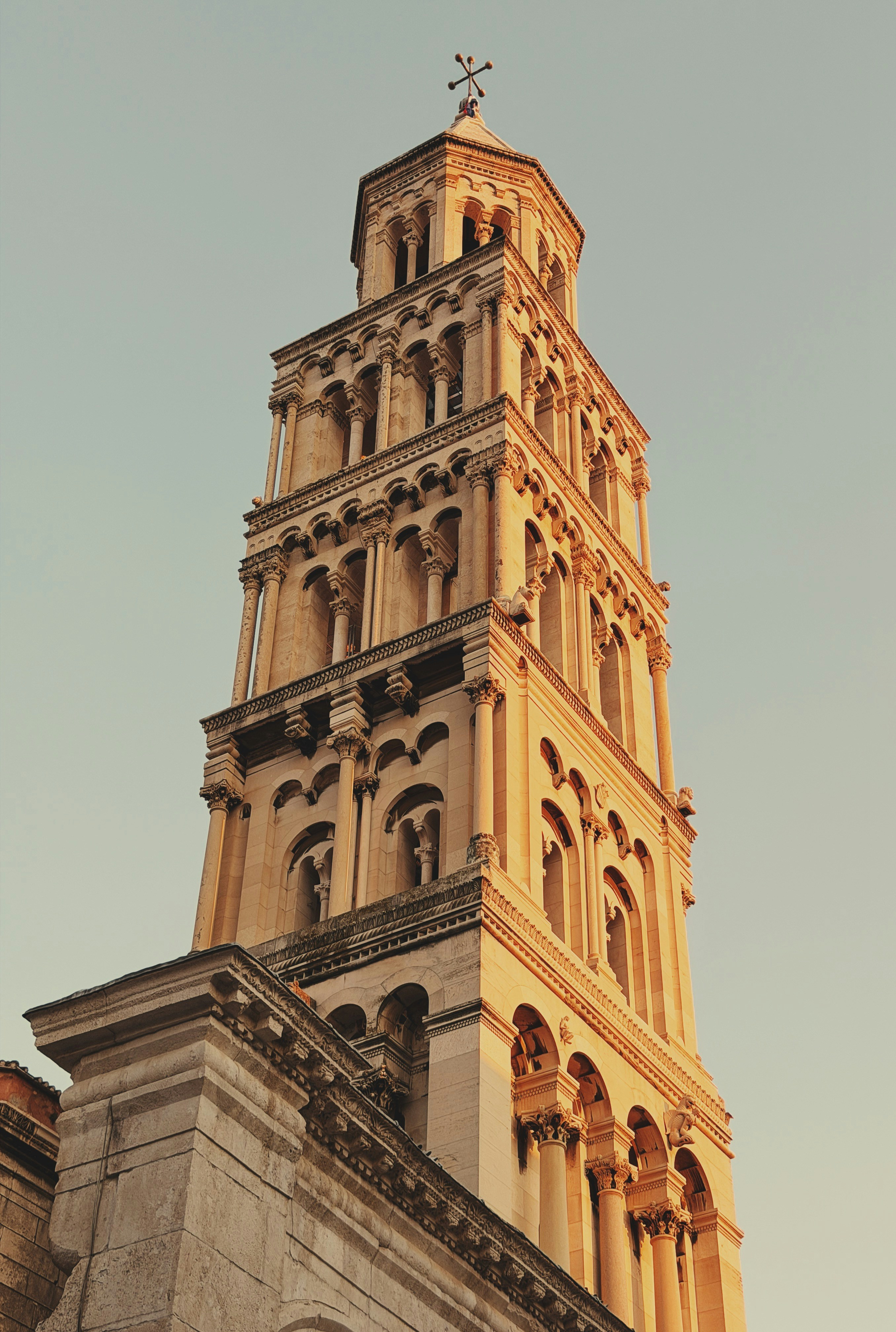 Sunlit Bell Tower Ascending Toward a Clear Sky