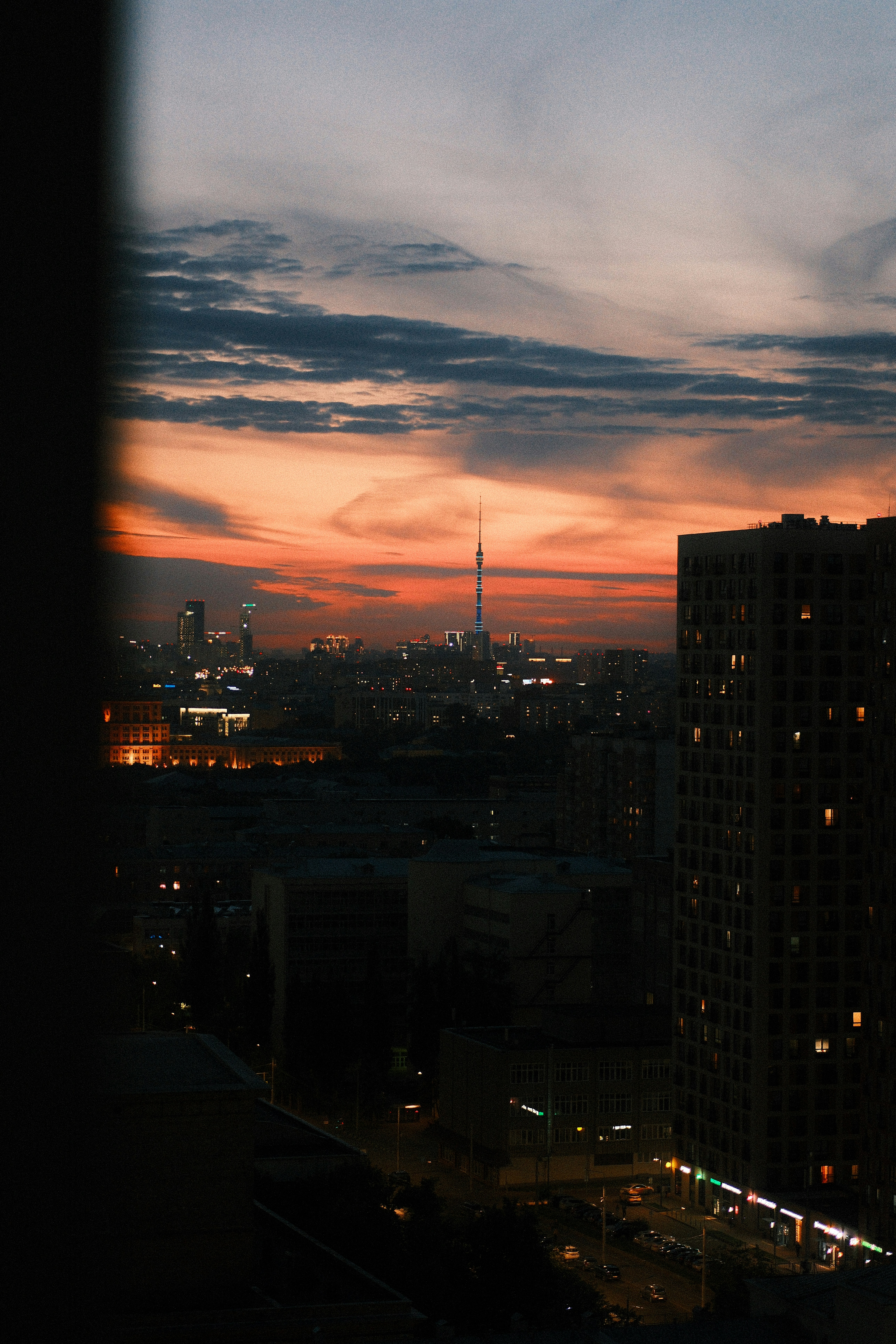 Dusk Over the City: Silhouette of a Tower Piercing the Horizon