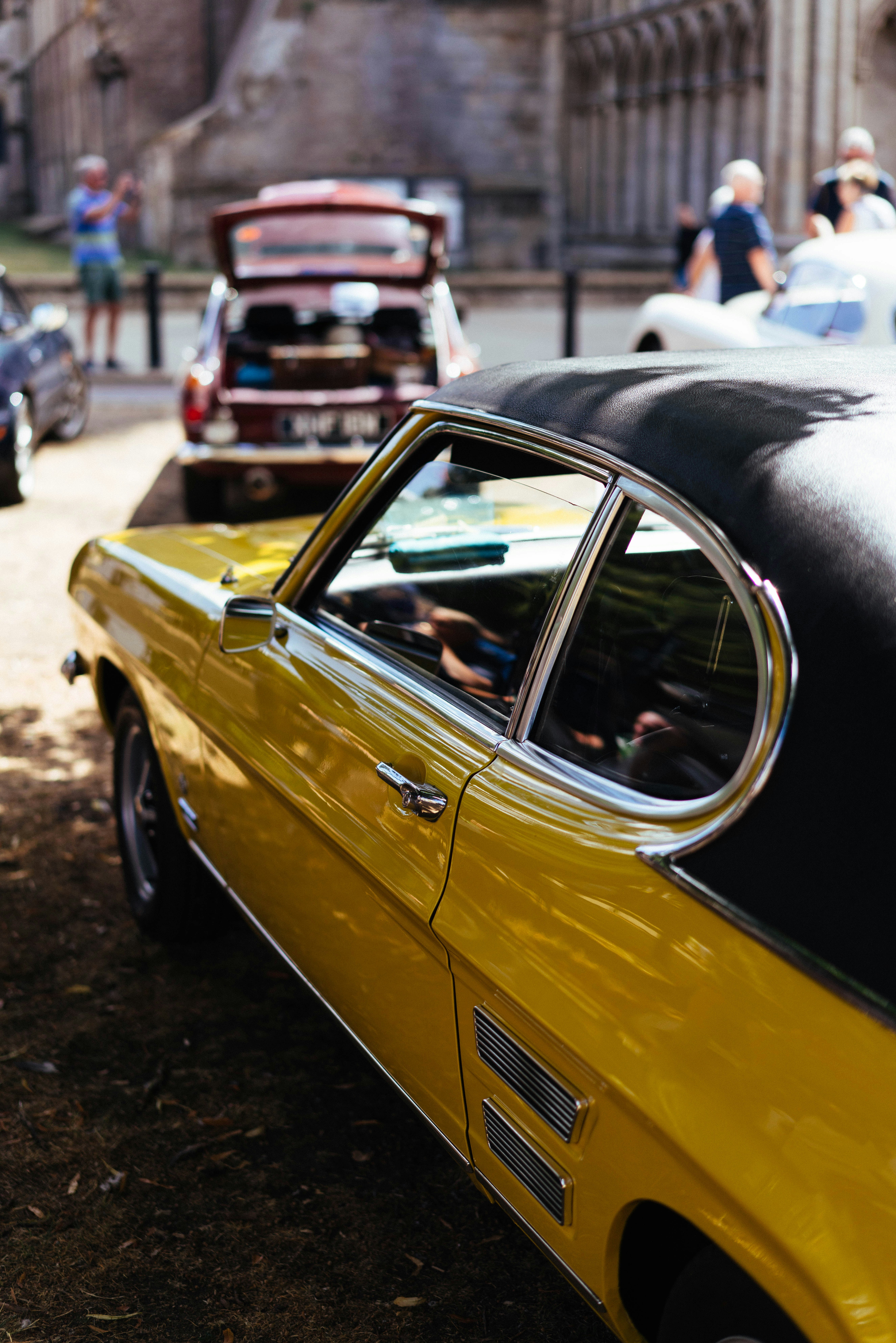 Yellow Classic Car in Front of a Vintage Car Show