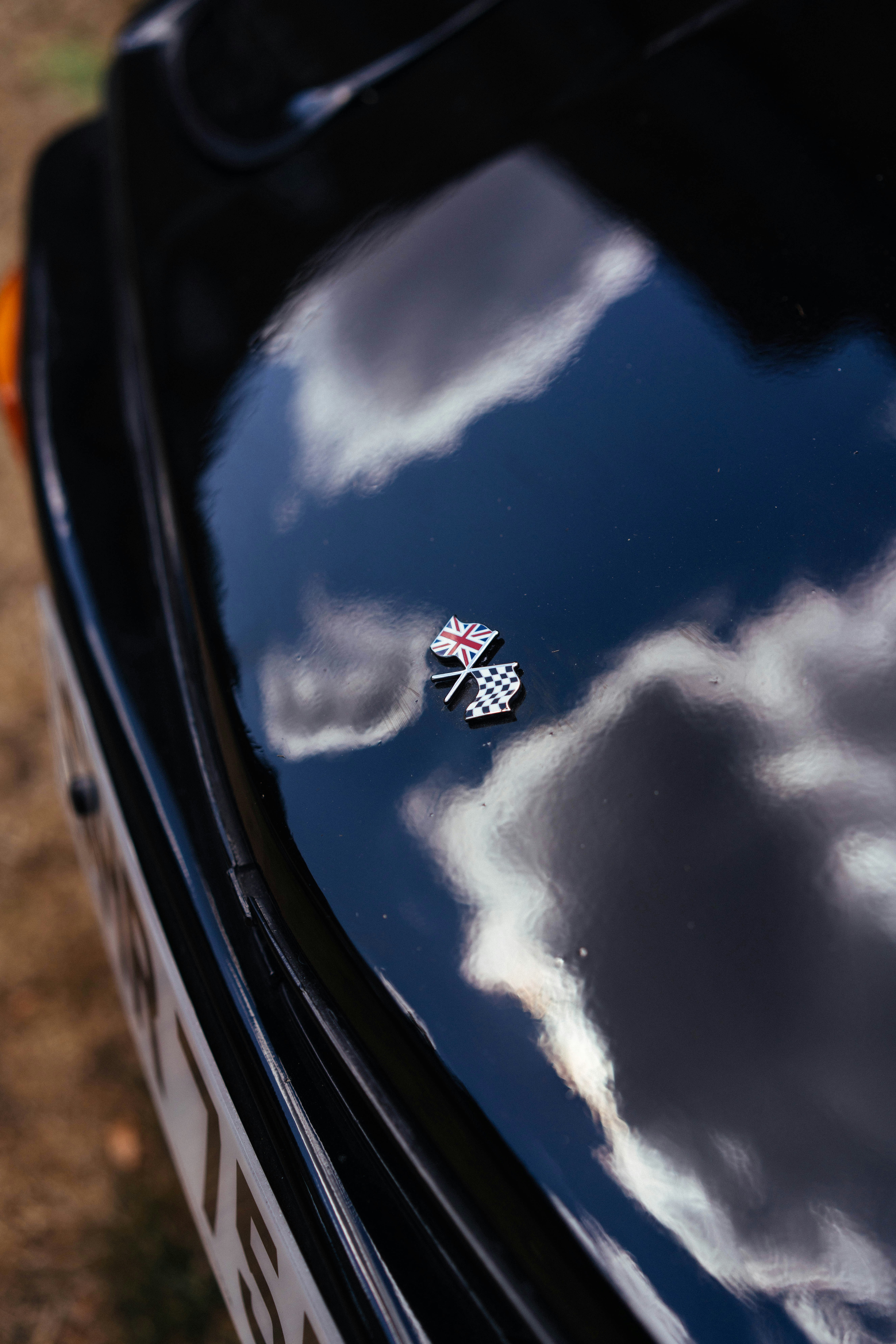 Emblem on Night-Gloss: Union Jack and Checkered Flag Adorning a Car Hood