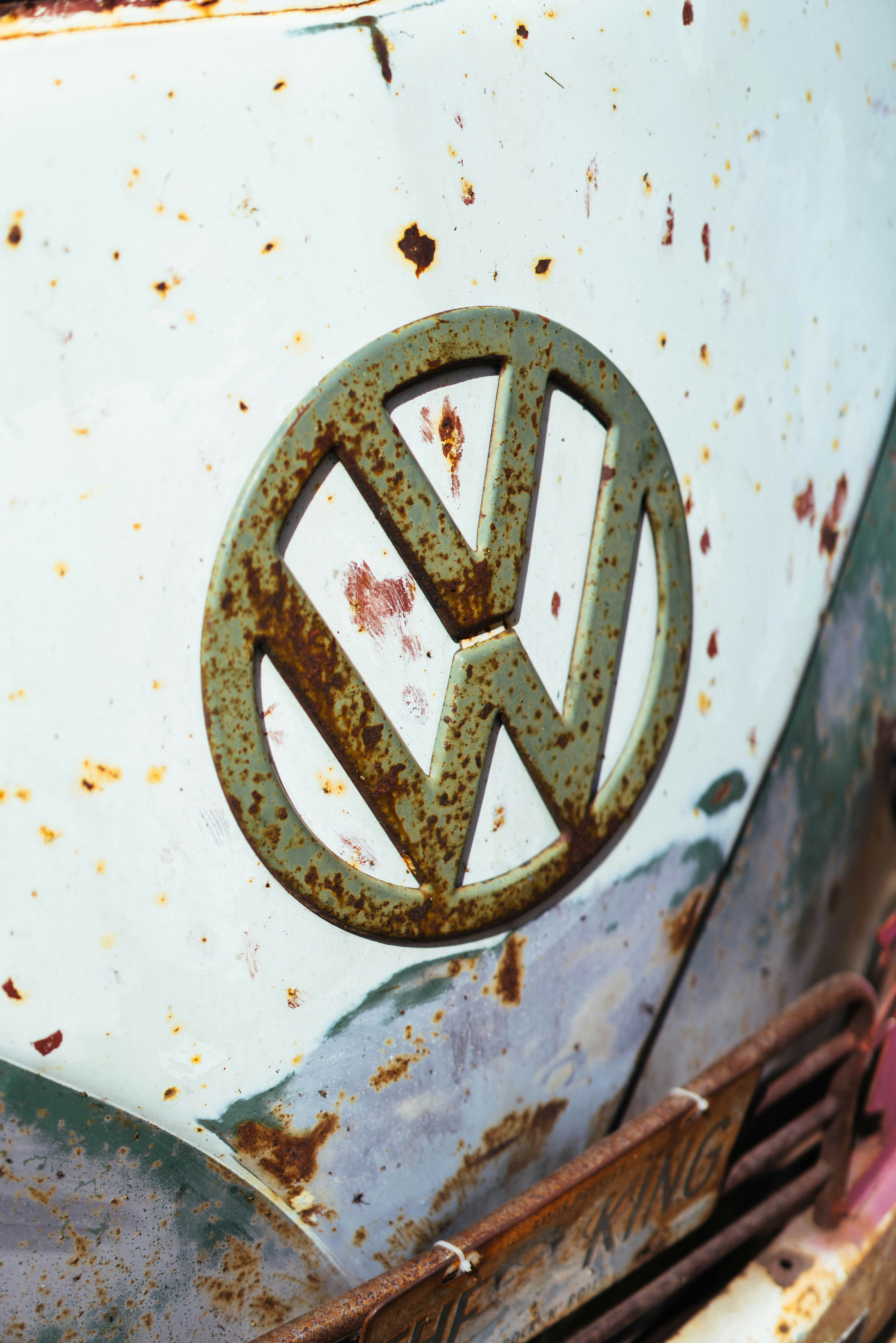 Weathered VW Emblem: Rusted Echoes of a Distant Road