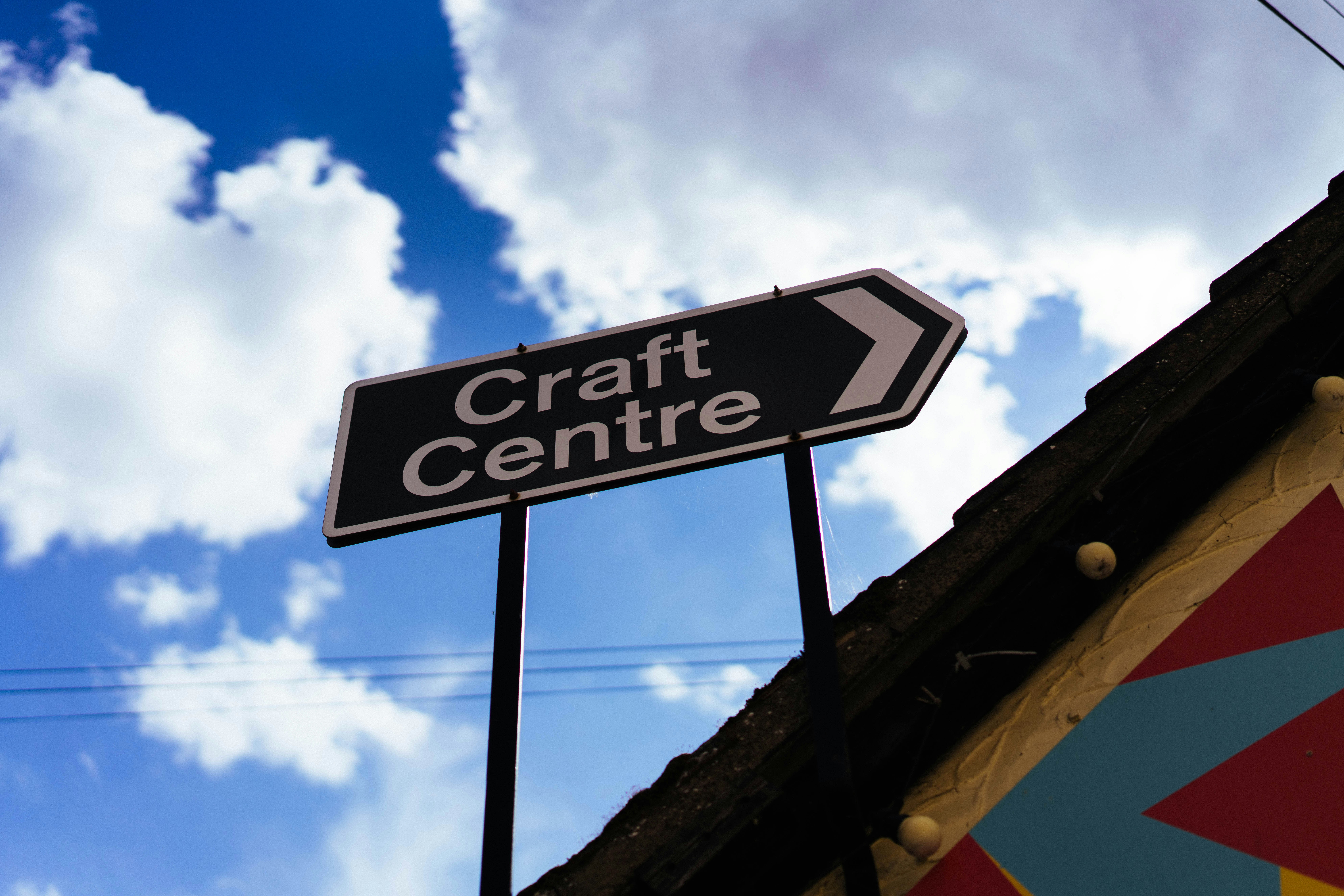 Signpost to Craft: A Skyward Moment Framing a Busy Corner