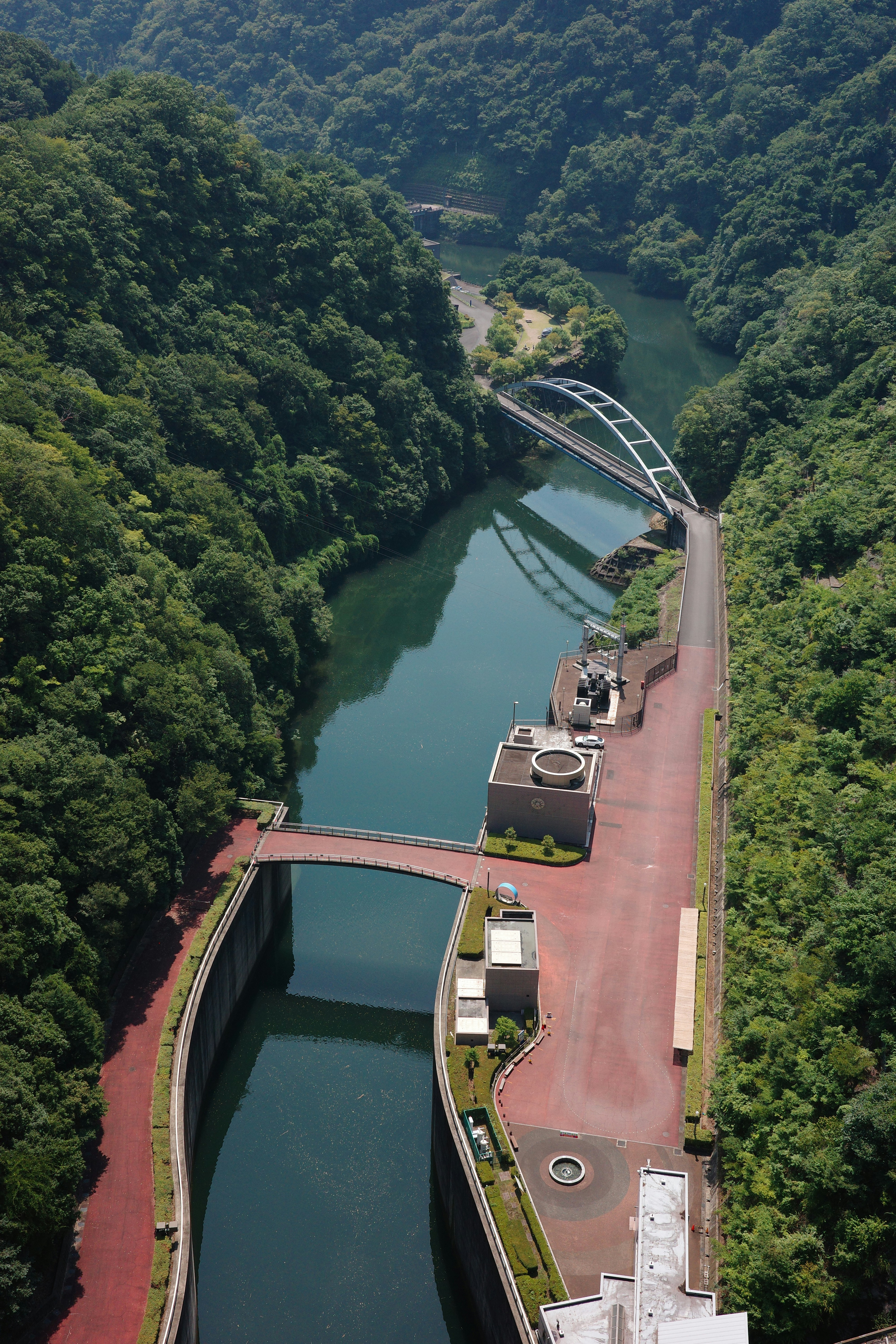 Aerial Grasp: Concrete Channel Winding Through Verdant Gorge