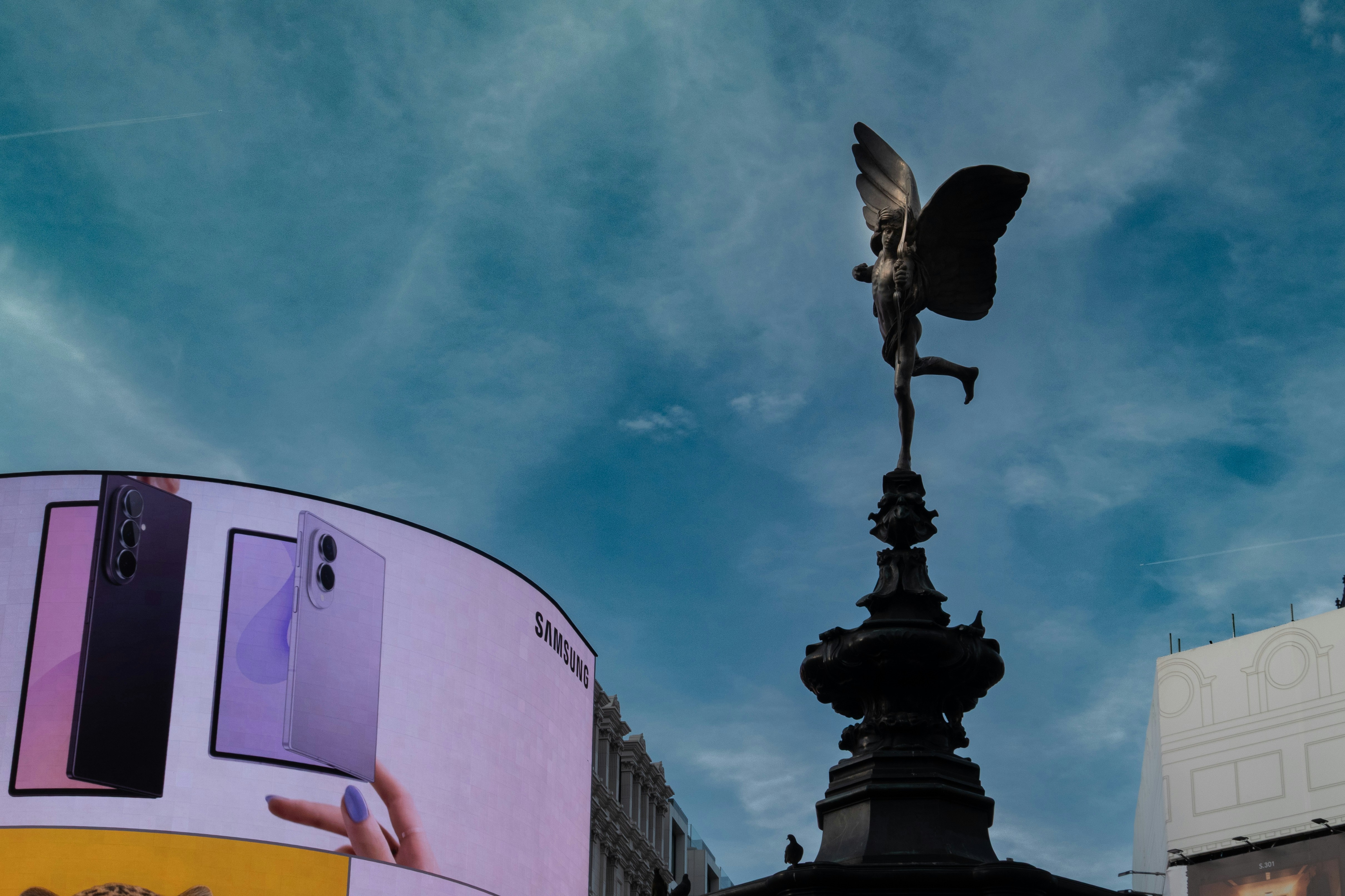Winged Monument Above the City: A Street Corner and a Statue silhouette