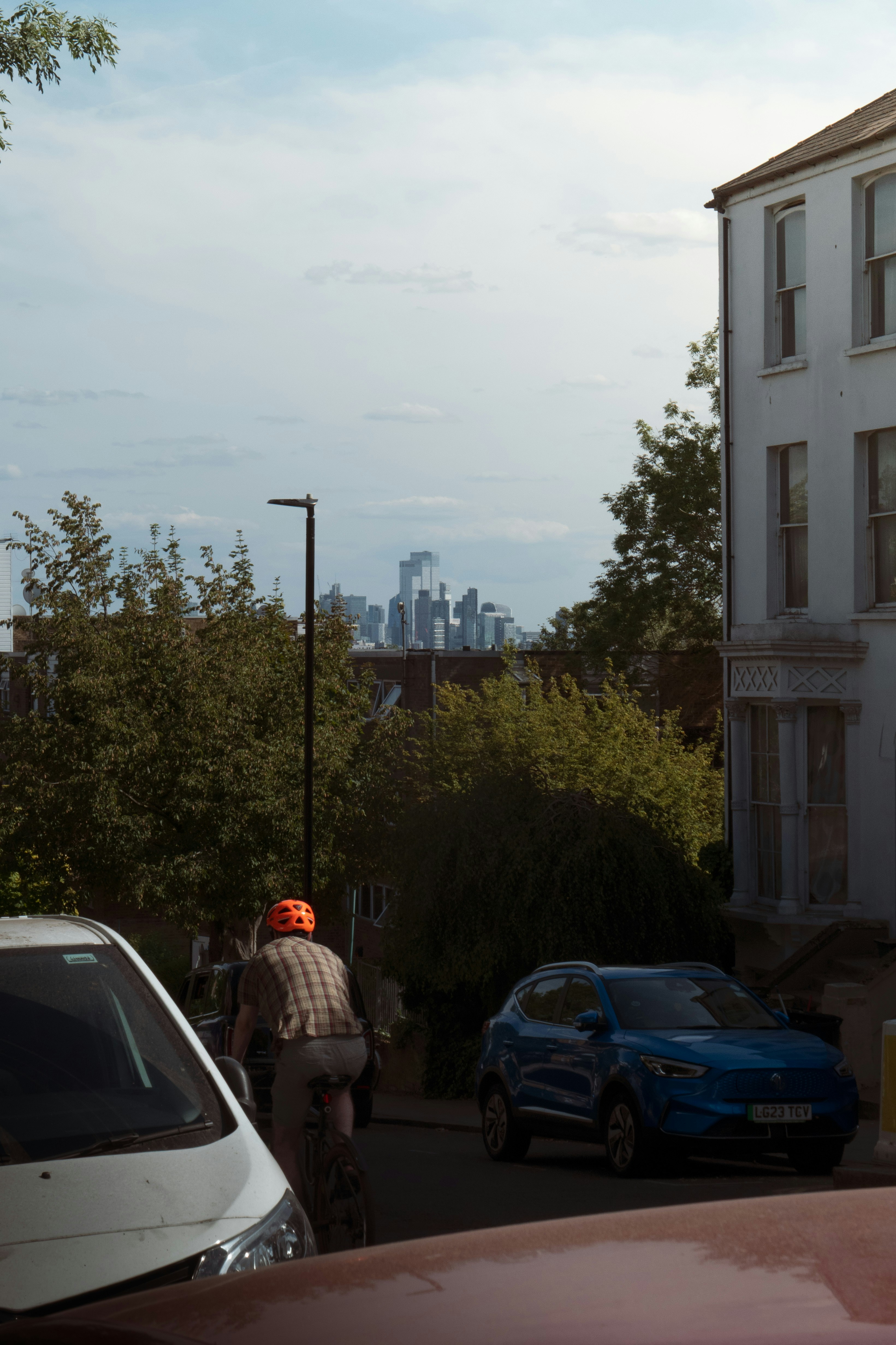Urban Ascent: A Cyclist's Quiet Climb Below a Distant Skyline