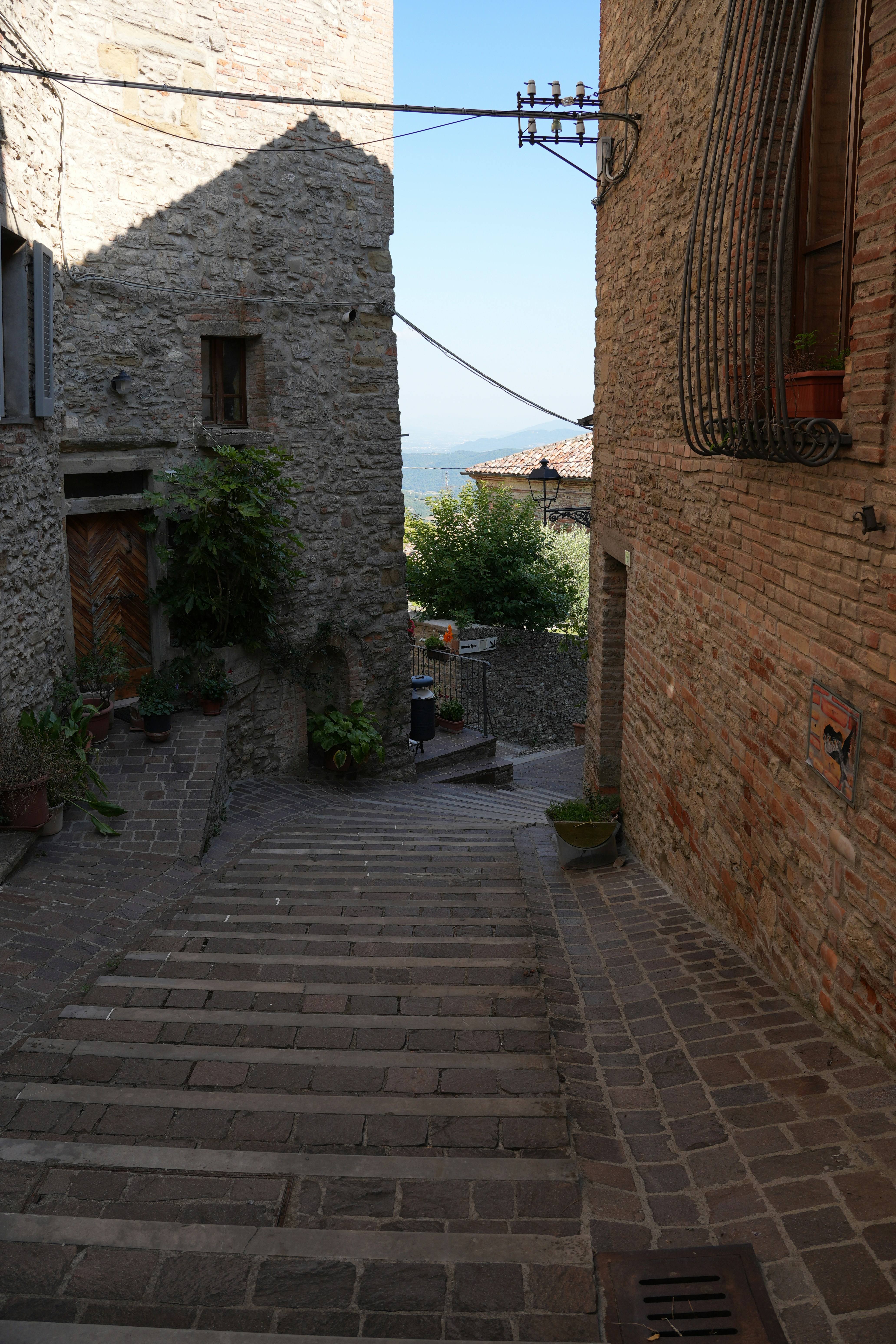 Cobbled Staircase Between Stone Facades Toward a Distant Village