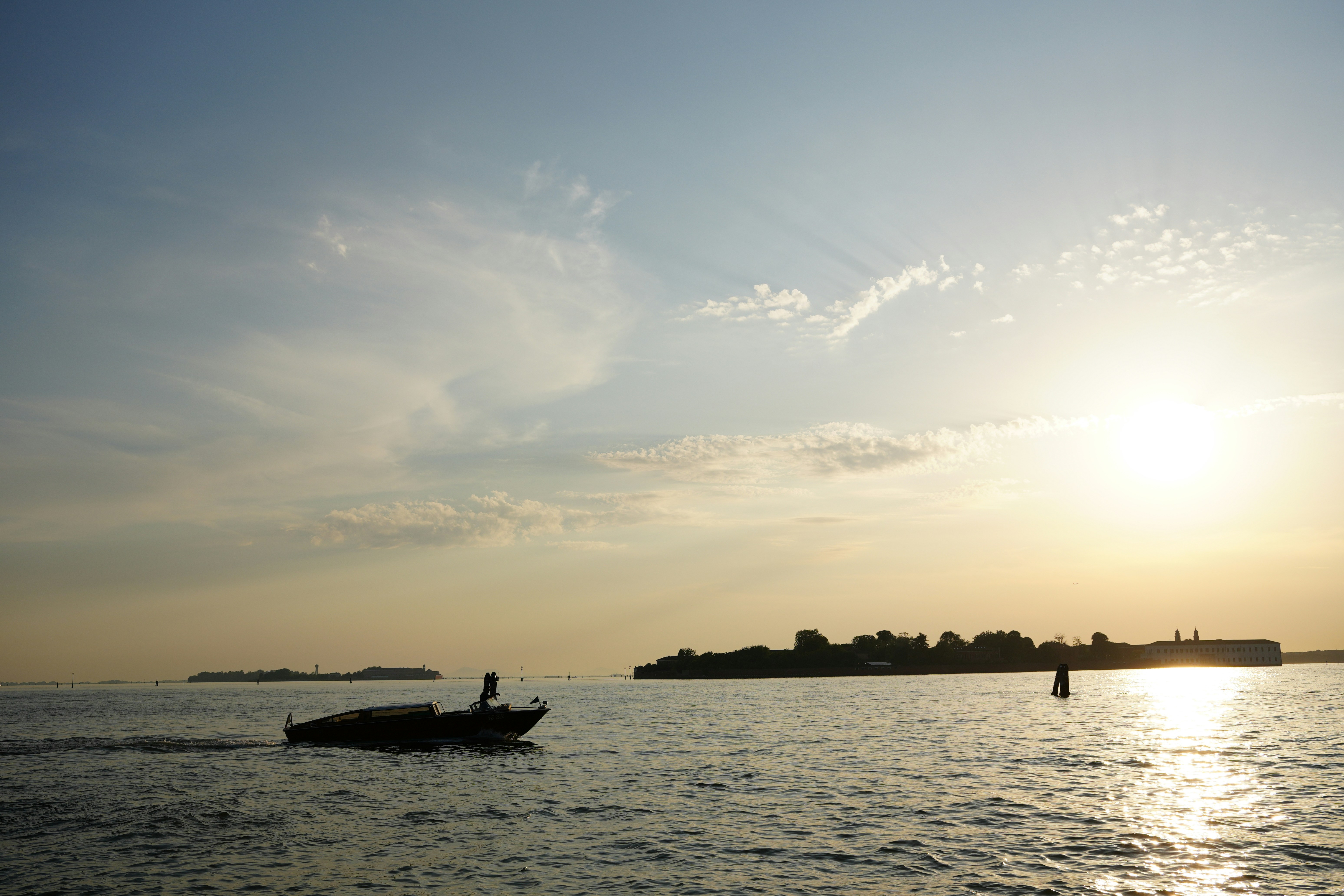Sunlit horizon over calm sea with distant vessels
