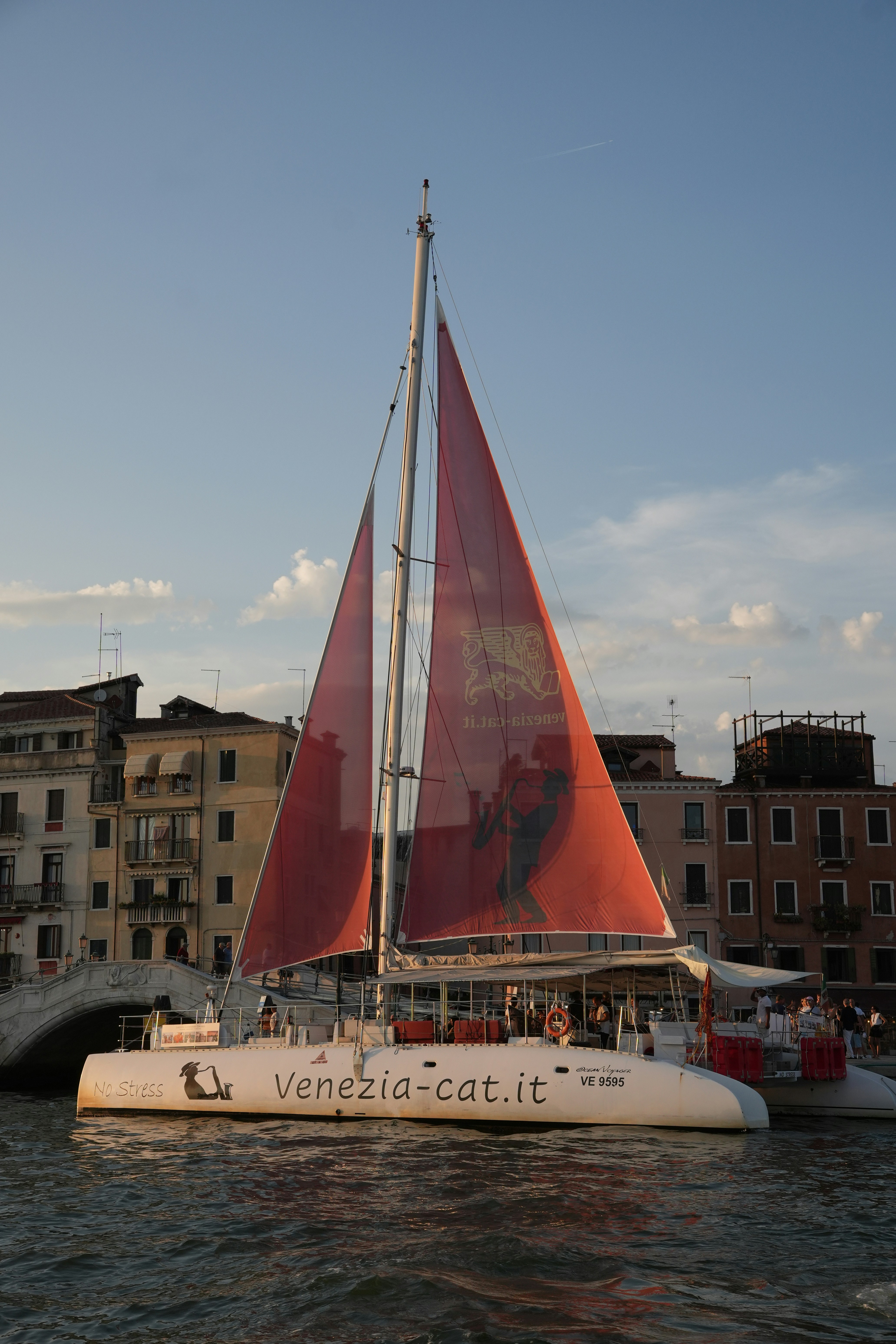 Sailing through San Marco: A crimson mainsail in sunset light