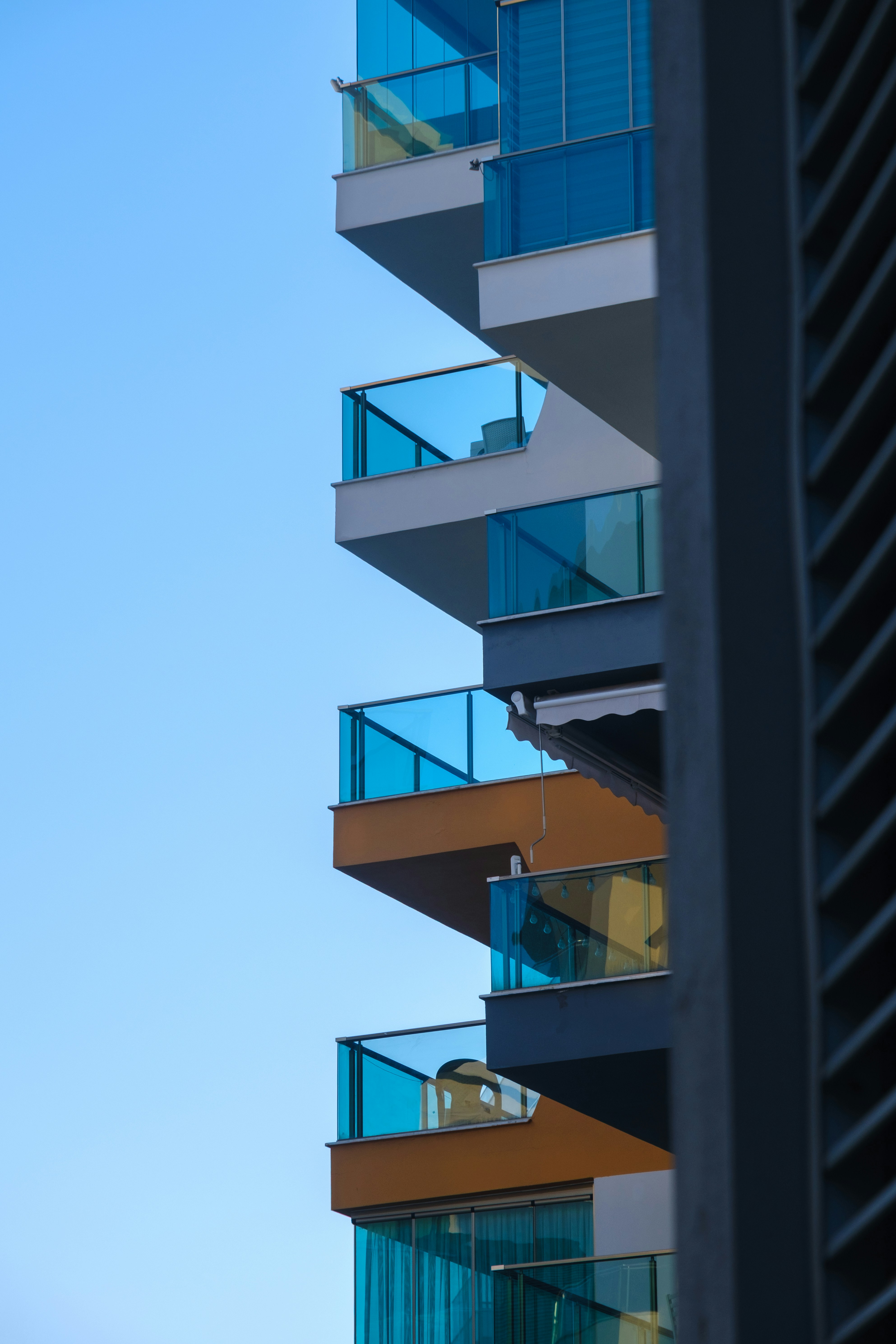 Vertical Cascade of Colored Balconies Against a Blue Sky