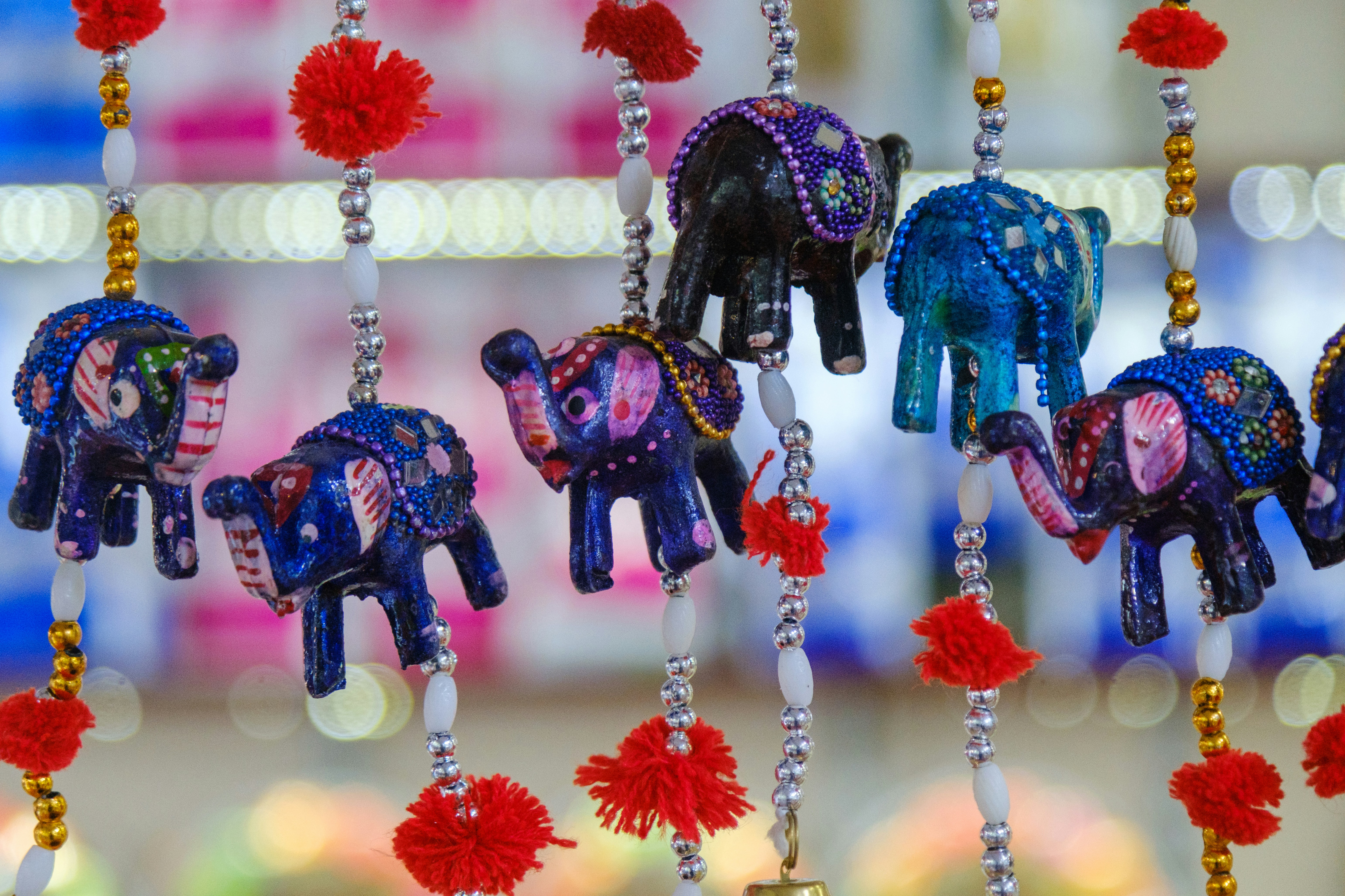 Beaded Parade: Handcrafted Elephant Ornaments Dangle in a Colorful Bazaar