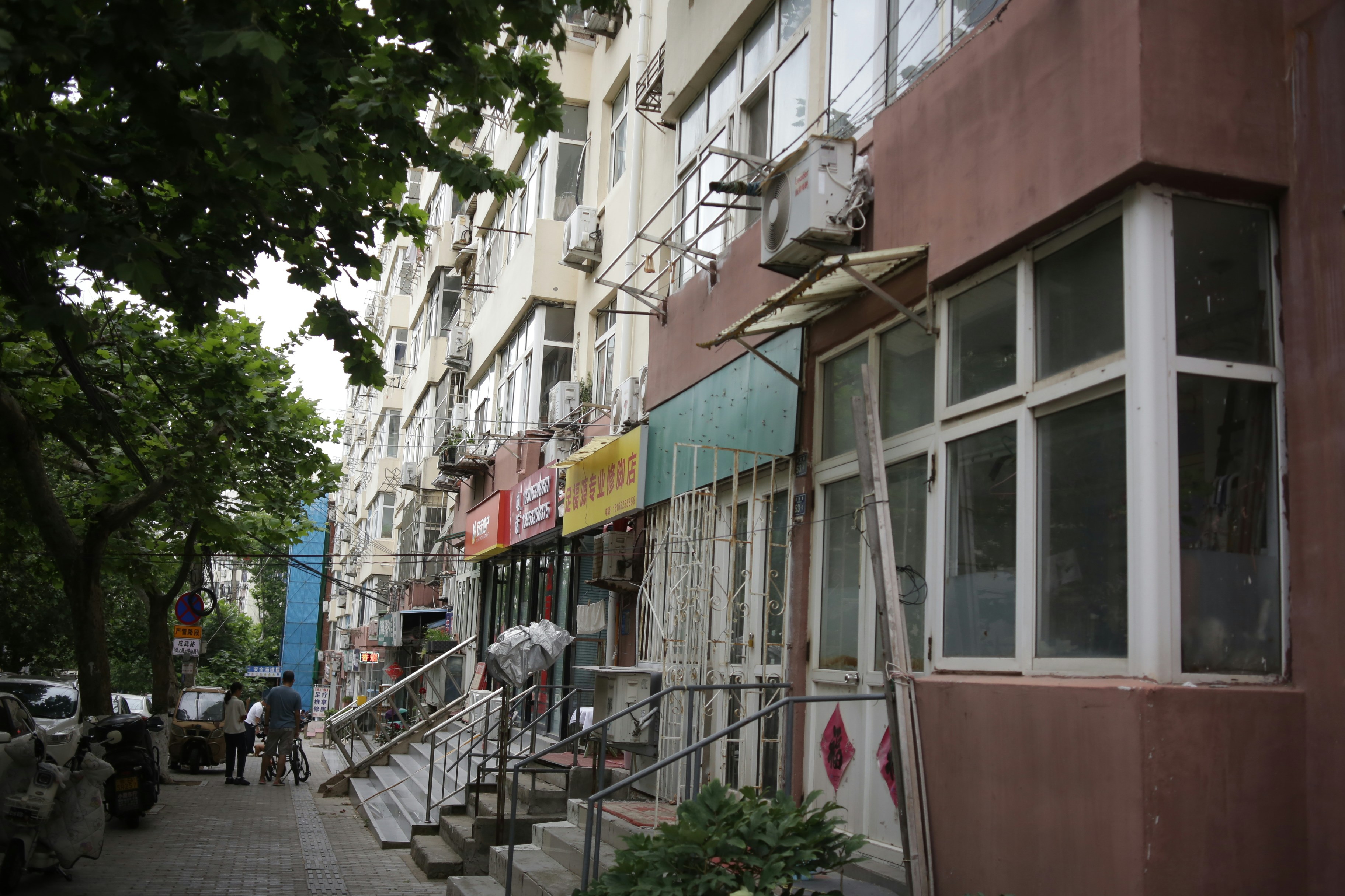 Urban Facade Corridor with Ground-Level Shops and Staircase