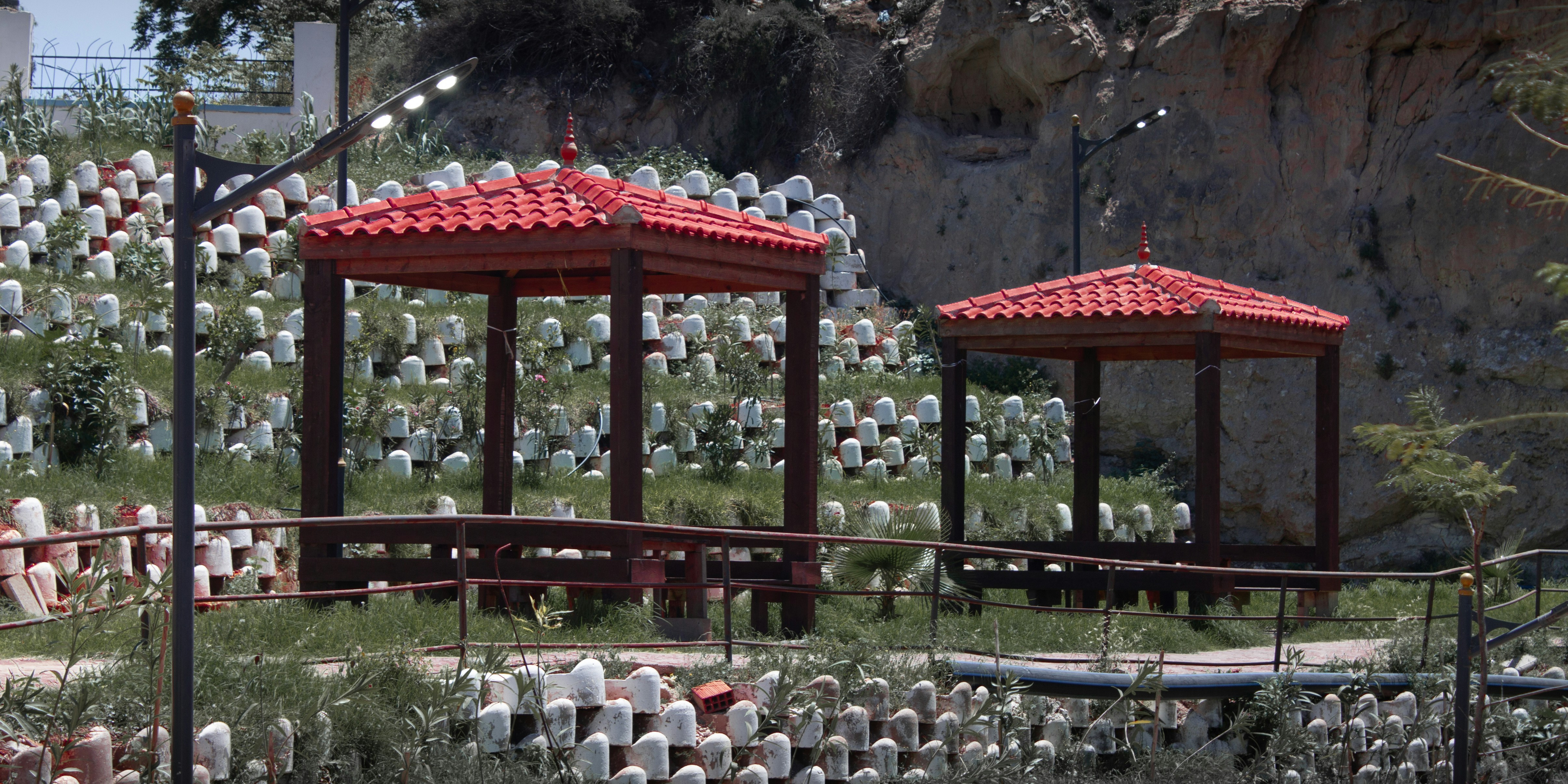 Red pavilions over a hillside of stone markers