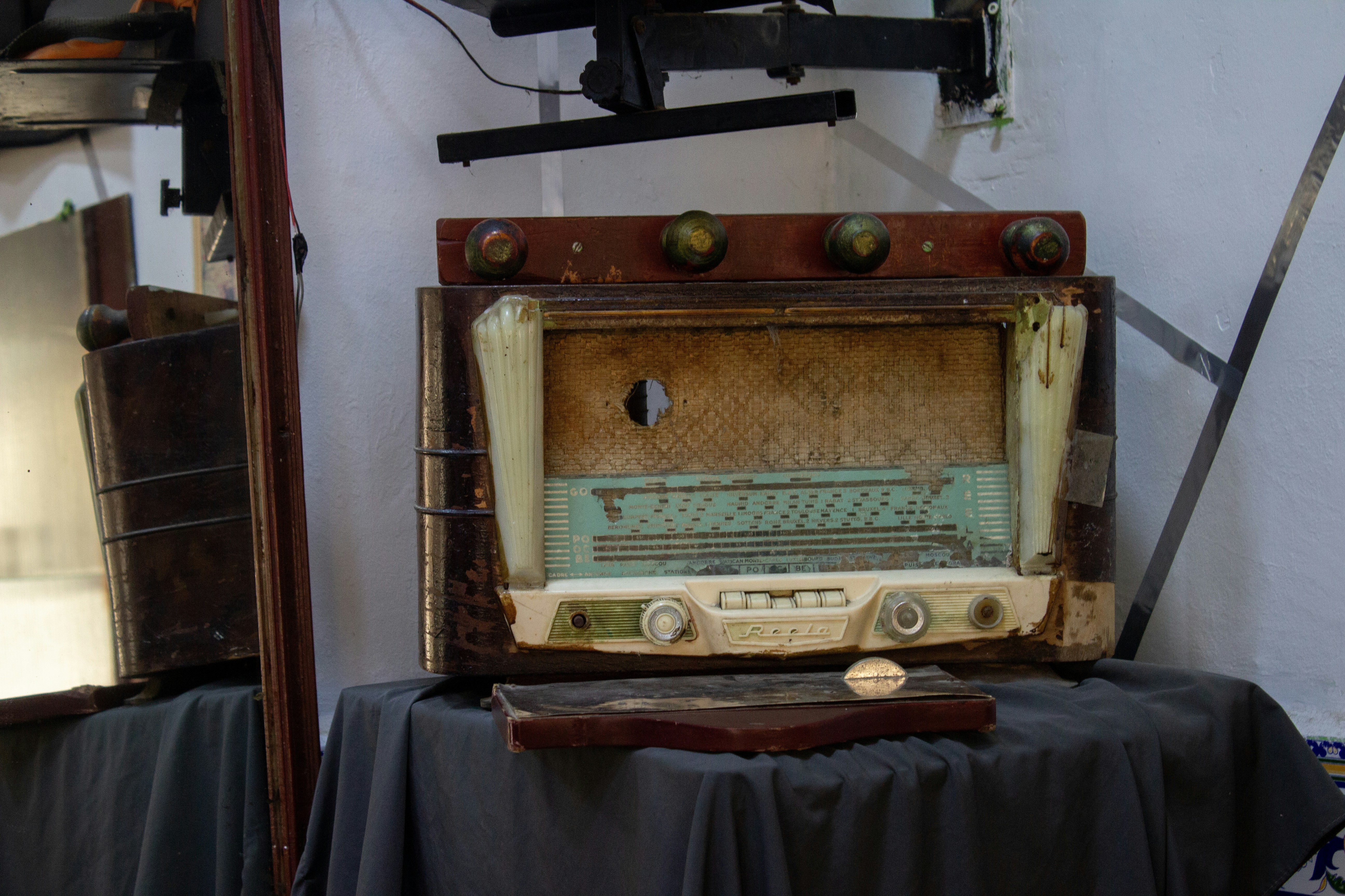 Dusty gramophone relic on a velvet pedestal awaits restoration