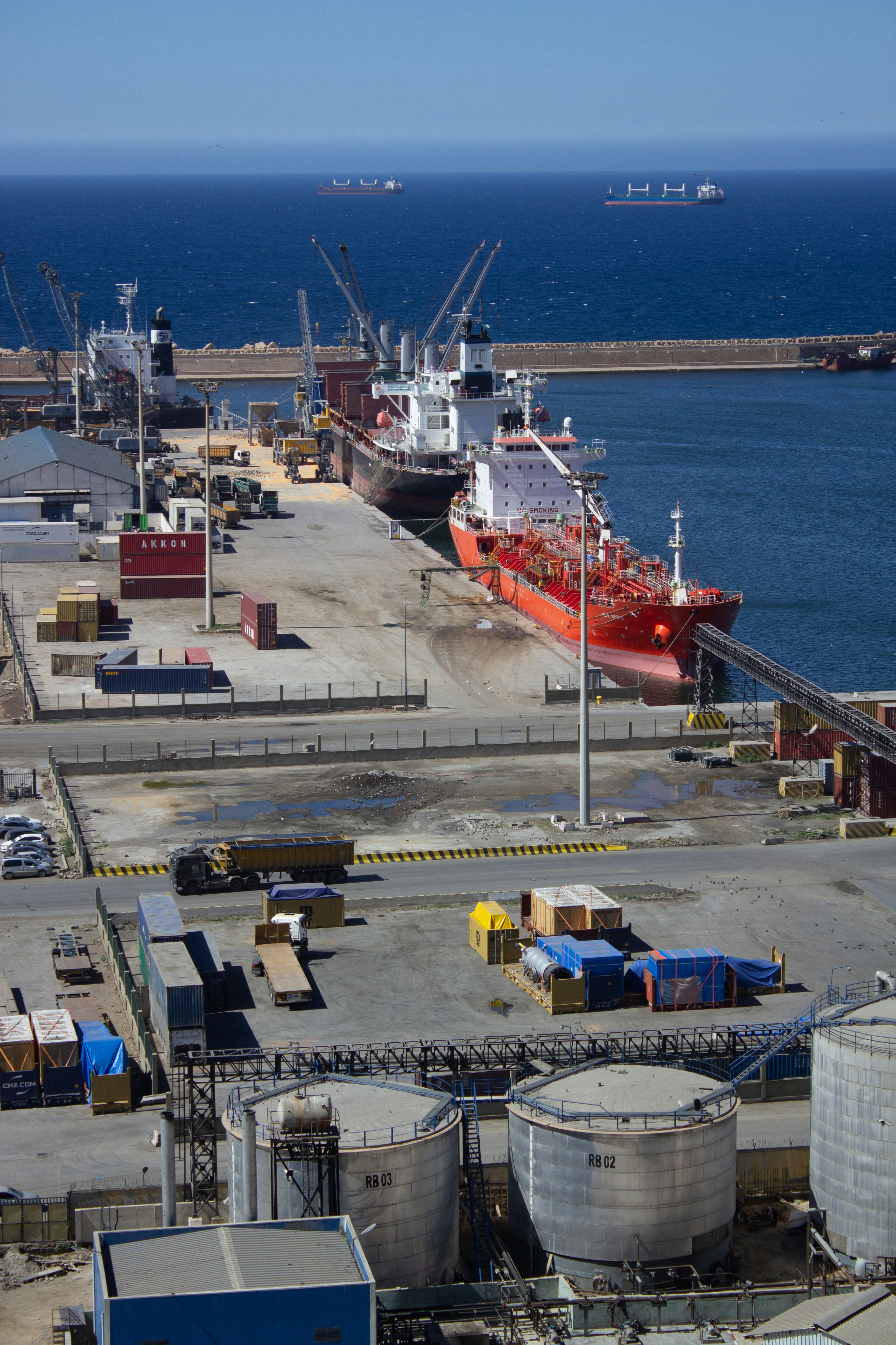 Harbor of Giants: Red Bulk Carrier at the Quay Under a Wide Atlantic Sky