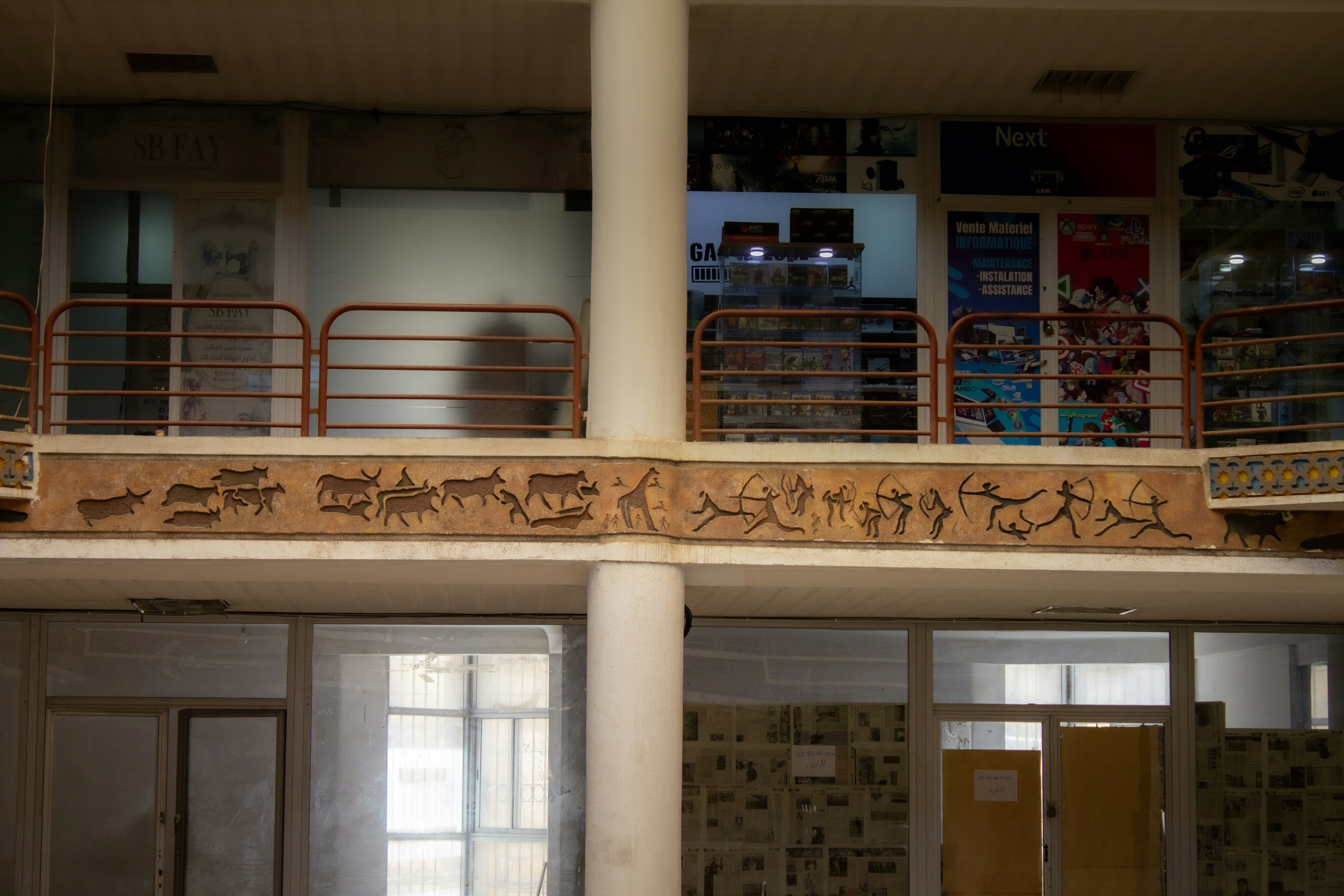 Stone frieze of running figures anchors a quiet mall terrace