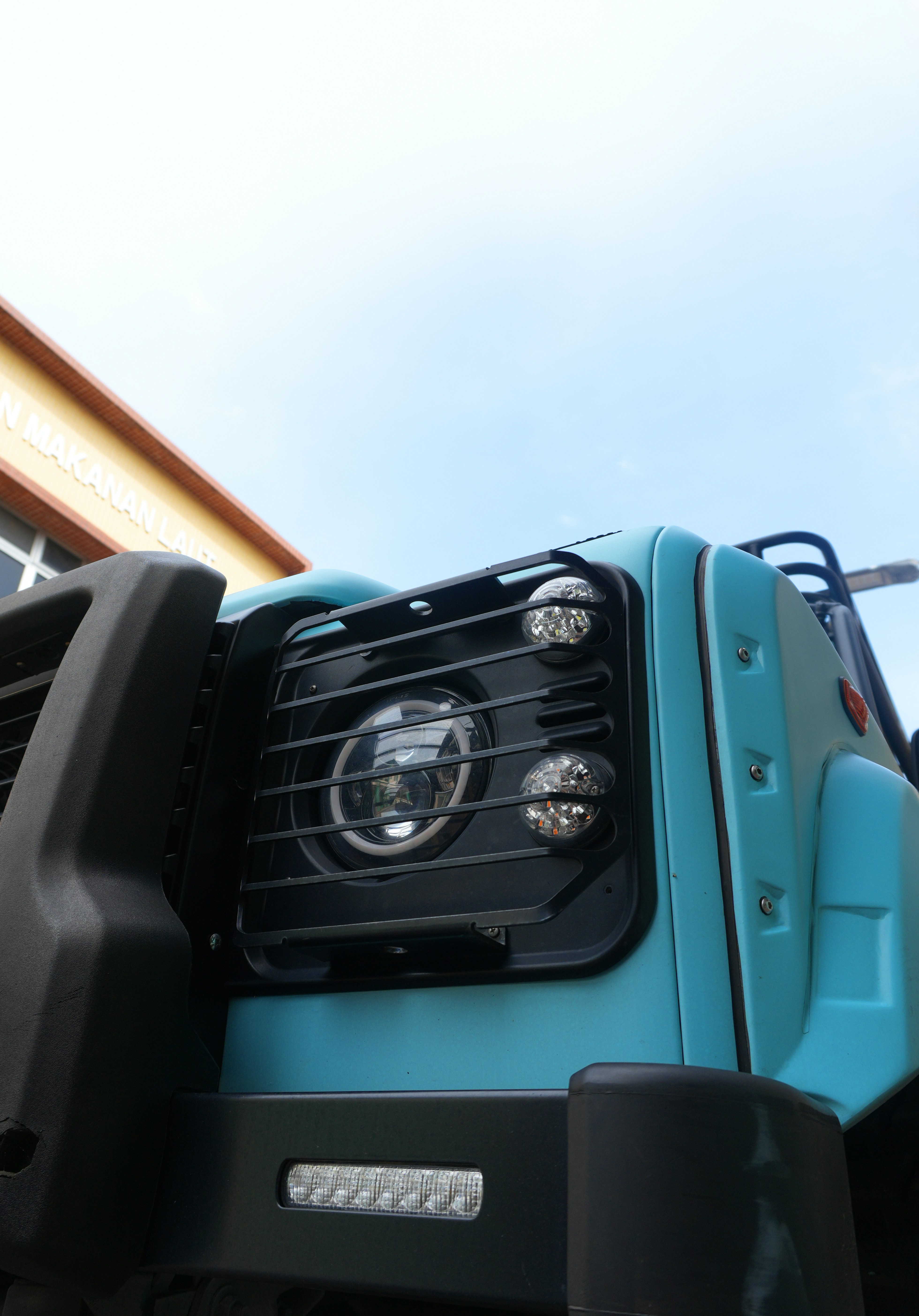 Front-Left View: A turquoise off-road beast with rugged LED grille